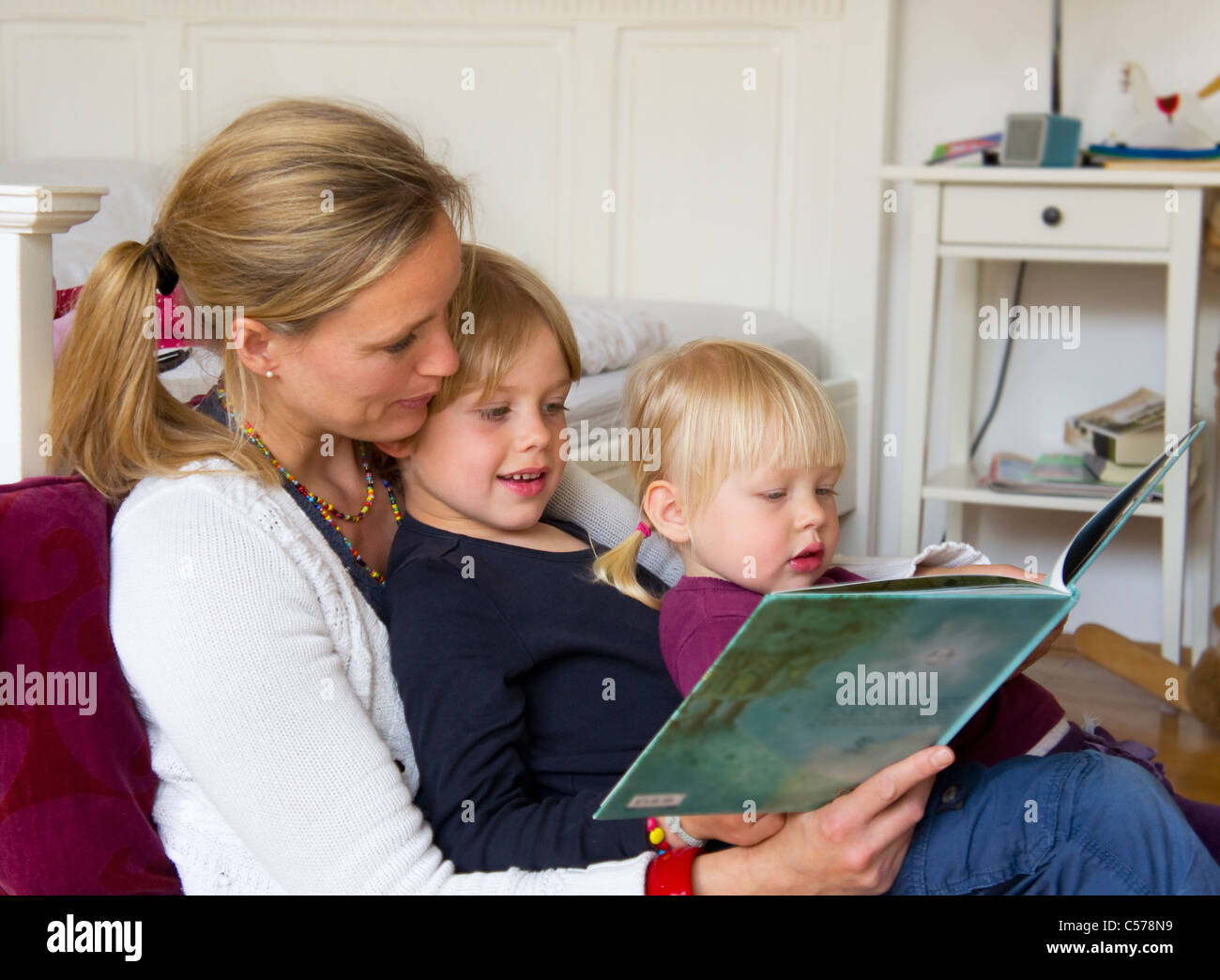 Mother reading to children in bedroom Stock Photo - Alamy