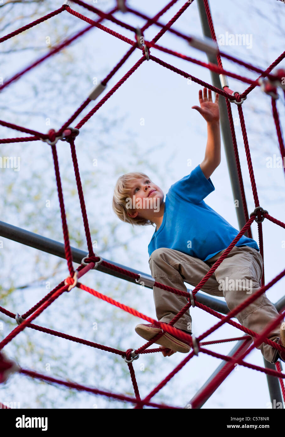 Boy climbing at playground Stock Photo - Alamy