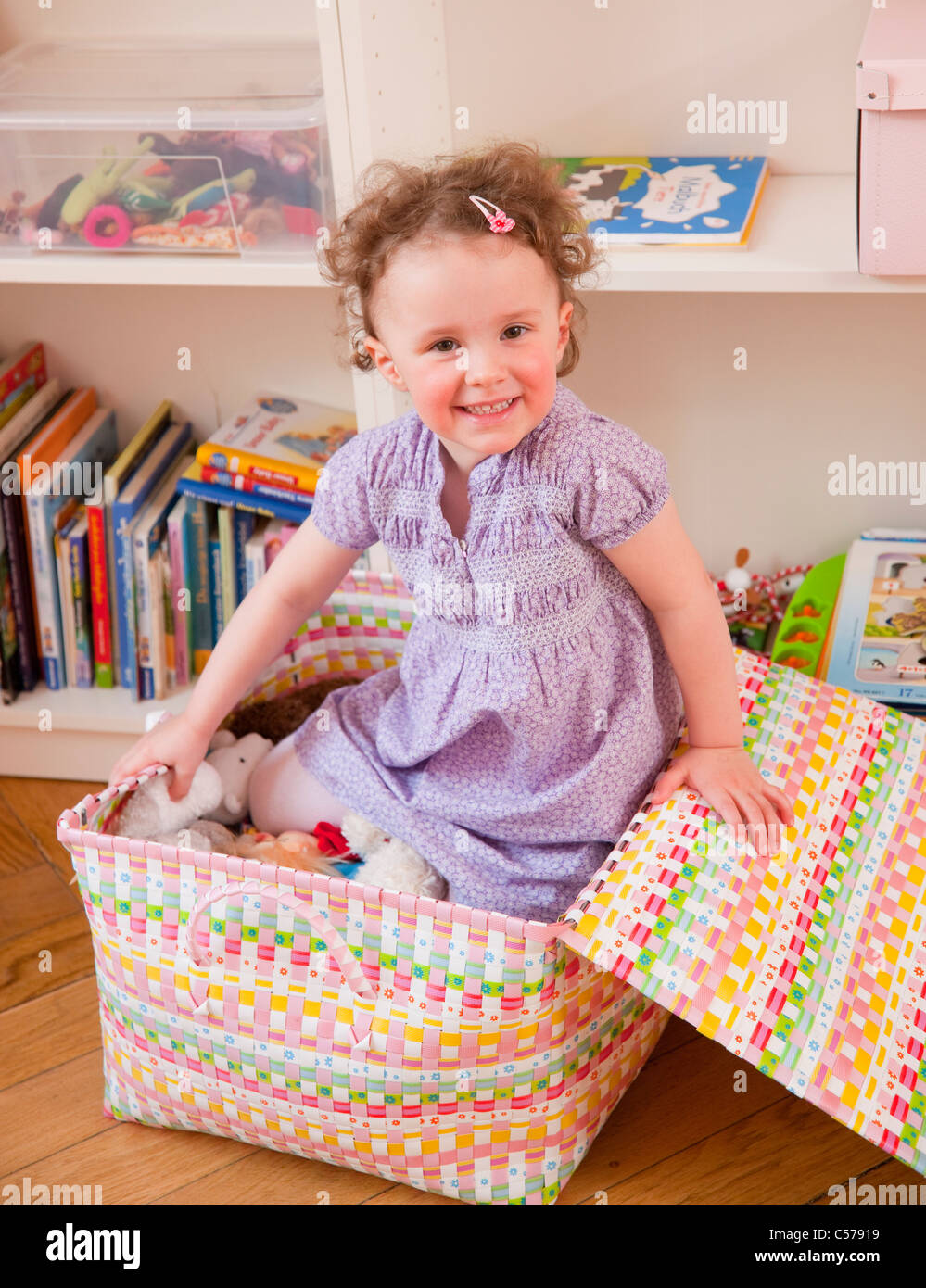 Smiling girl playing in toy basket Stock Photo - Alamy