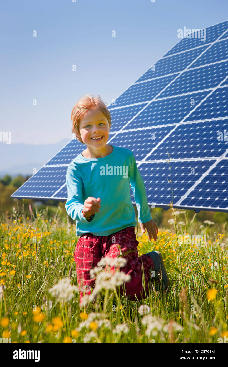 Boy playing in field by solar panel Stock Photo - Alamy