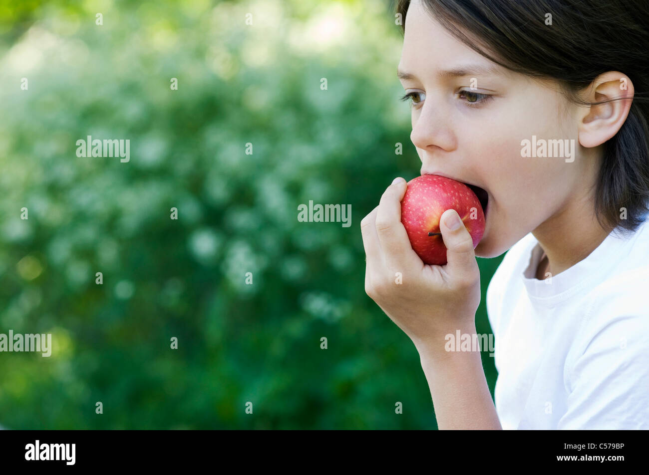 Boy eating an apple outdoors Stock Photo - Alamy