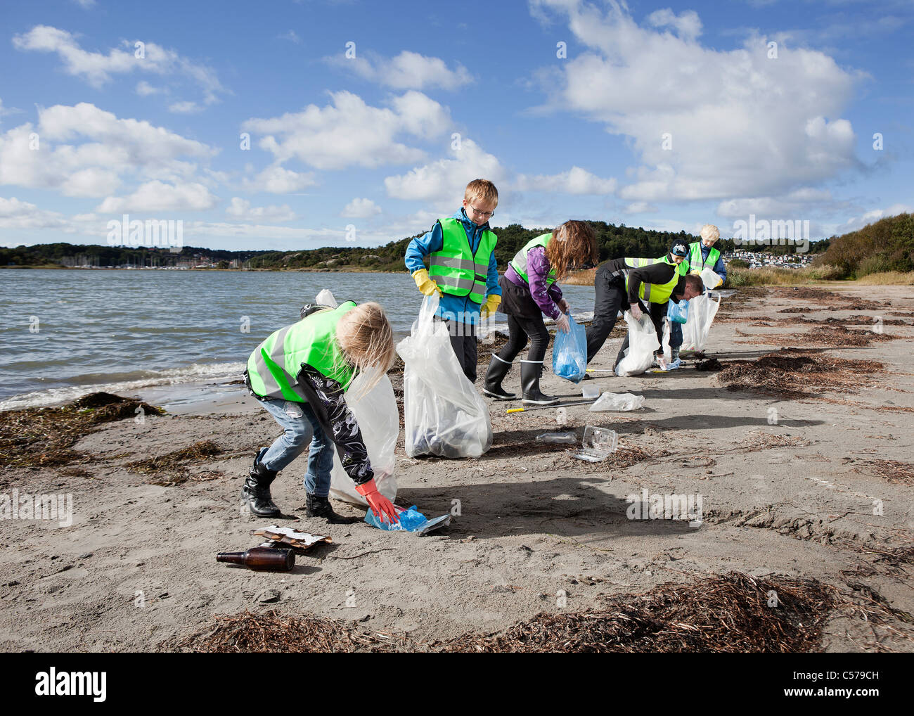 Group of workers cleaning beach Stock Photo - Alamy