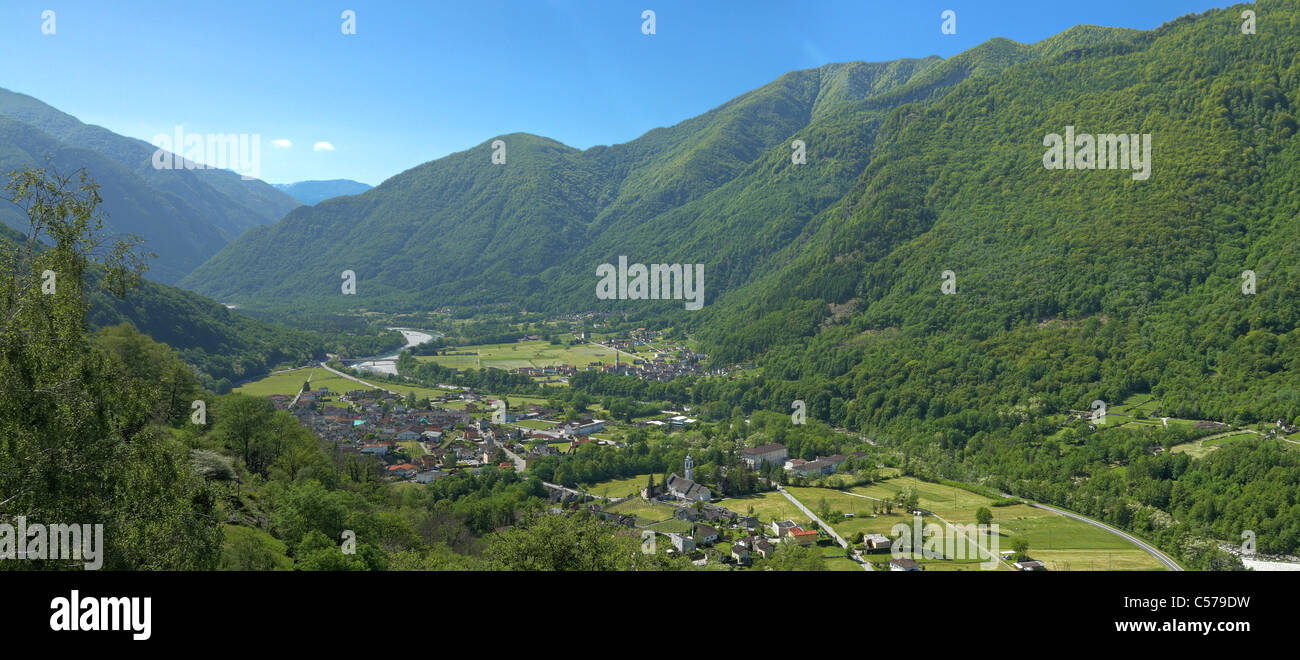 small town in the Maggia valley framed by high green, wooded mountains ...