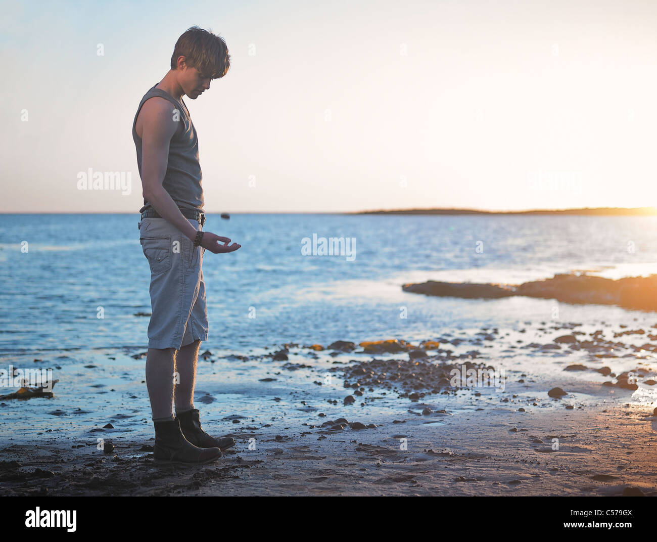 Boy tossing a pebble on beach Stock Photo - Alamy