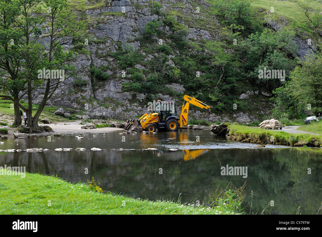 A jcb working on the stepping stones in dovedale derbyshire england uk ...