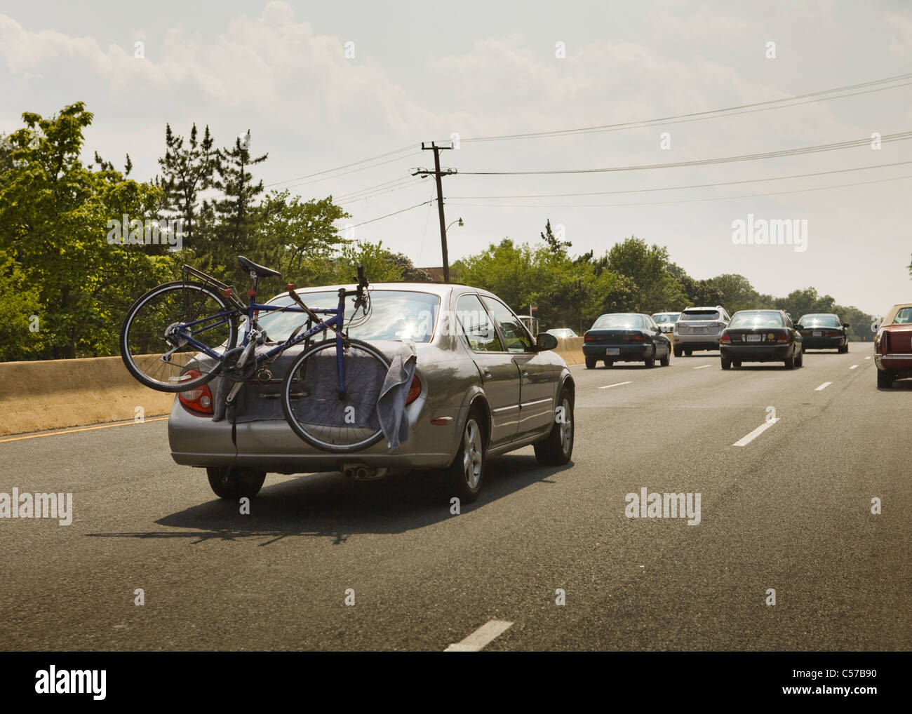 Car on highway with a rear mounted bicycle on trunk - USA Stock Photo ...