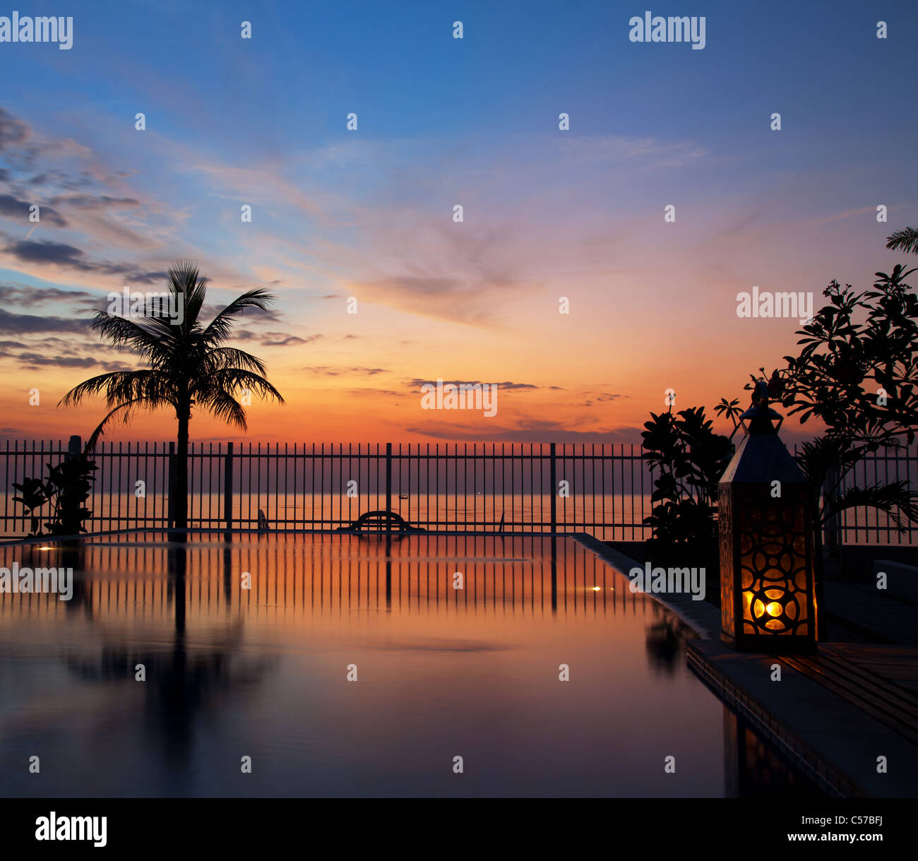 Stunning sunset with a reflection in infinity pool Stock Photo - Alamy