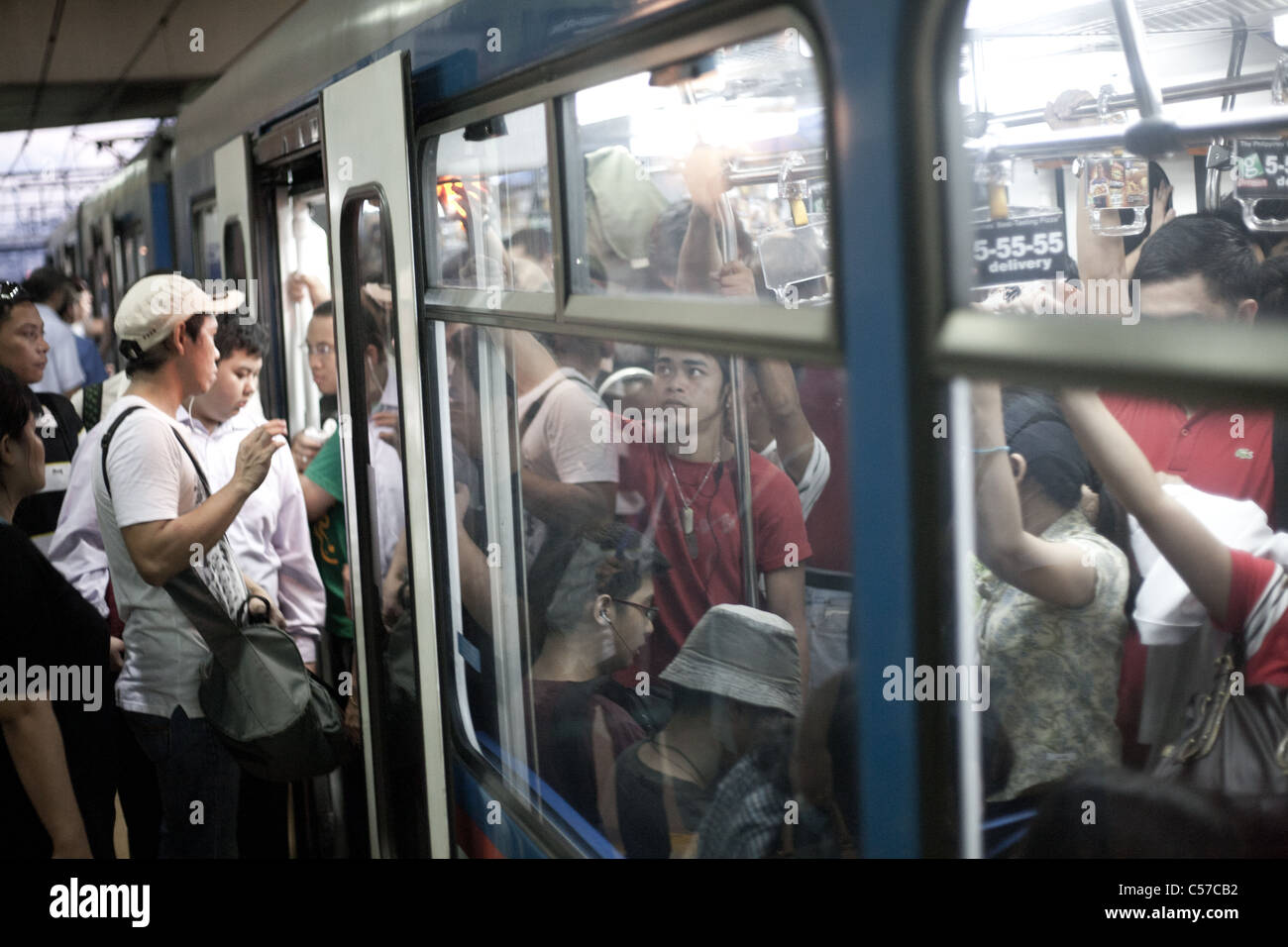 Commuters are trying to enter a crowded LRT train in Manilla Stock ...