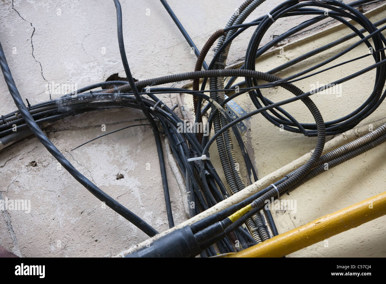 Cables and water pipe on abandoned exterior wall Stock Photo - Alamy