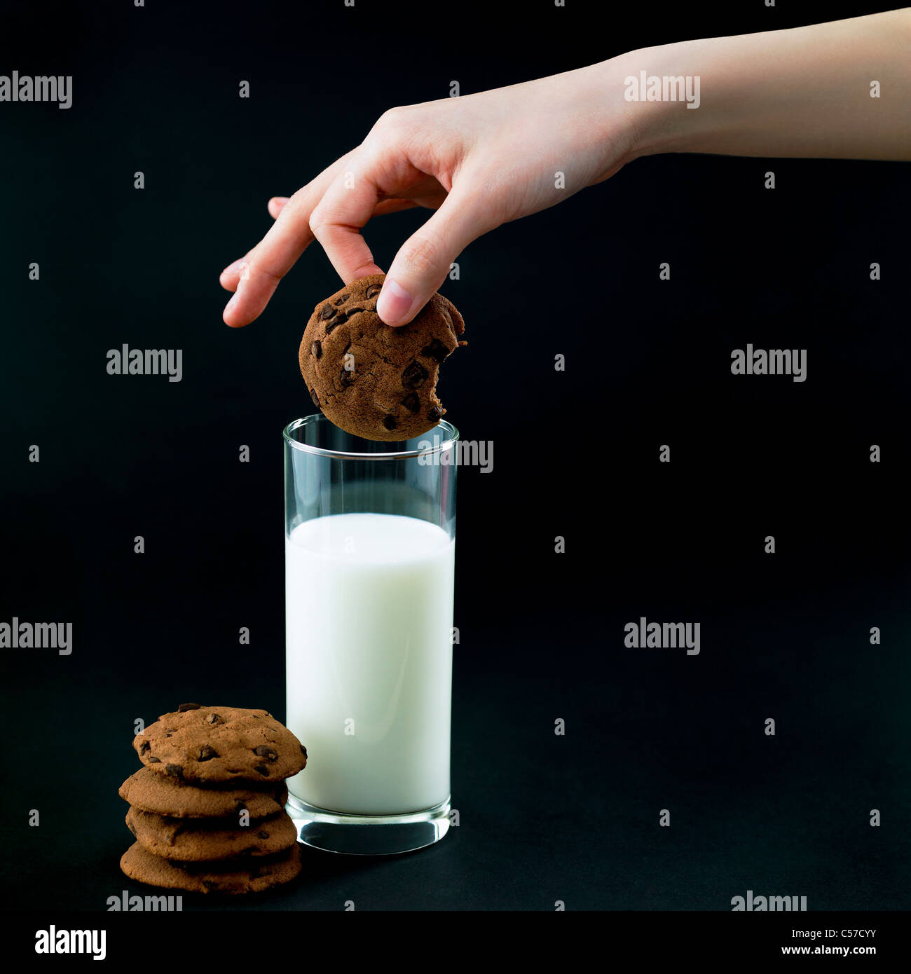 hand dip chocolate chip cookie in milk Stock Photo - Alamy