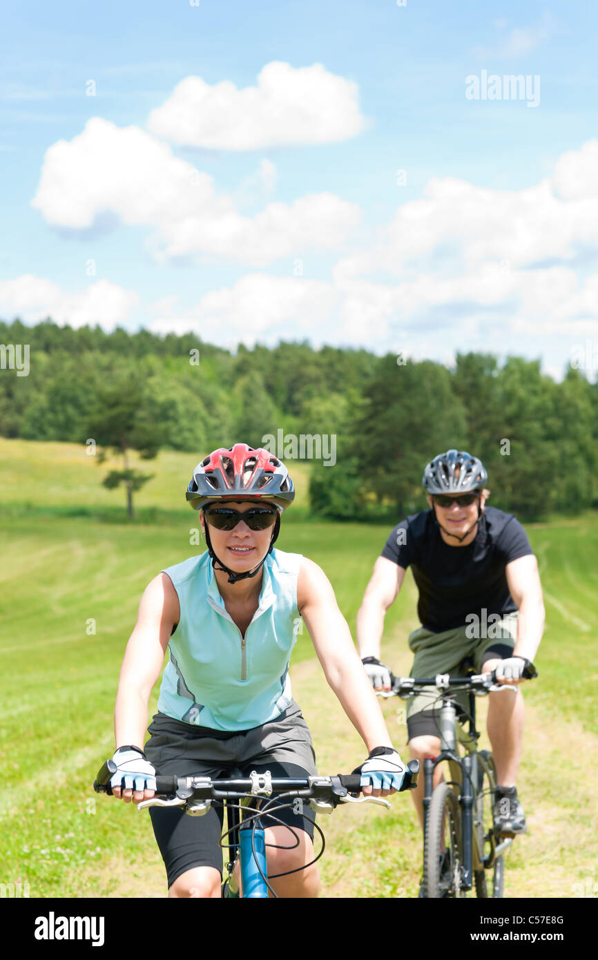 Sport couple riding mountain bicycles in coutryside meadows Stock Photo ...