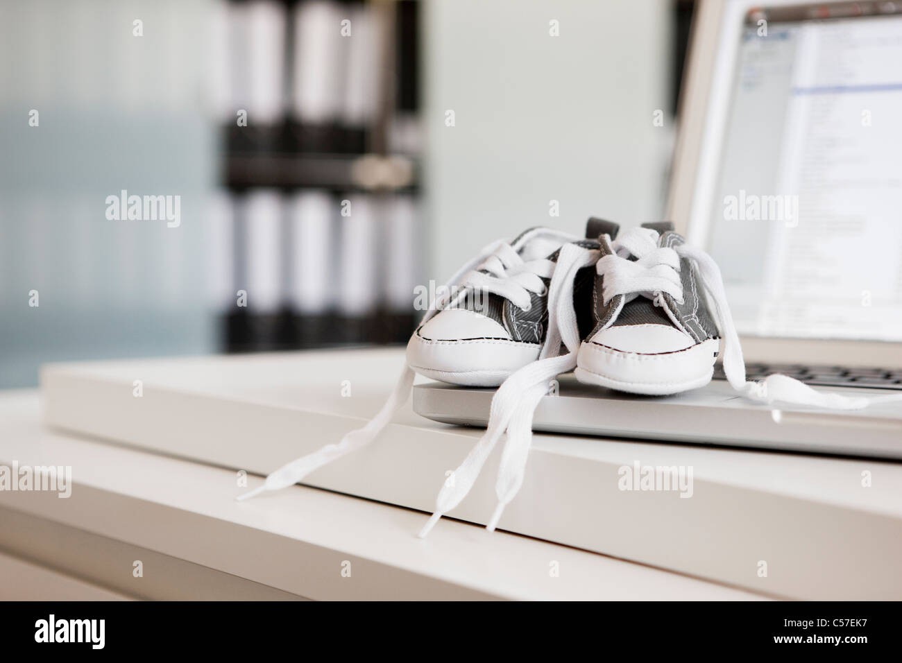 Baby shoes on laptop Stock Photo - Alamy