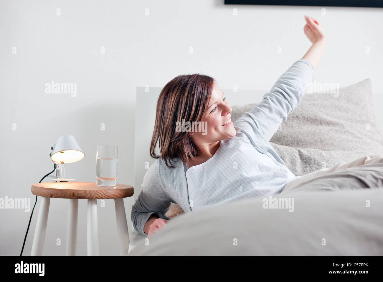 Woman stretching in bed Stock Photo - Alamy