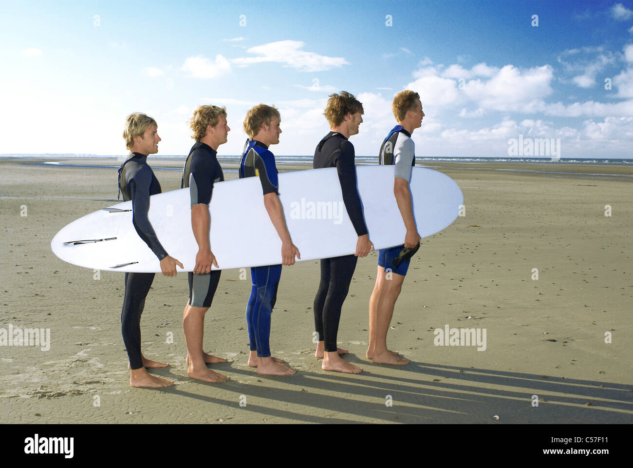 Men holding surfboard together Stock Photo - Alamy