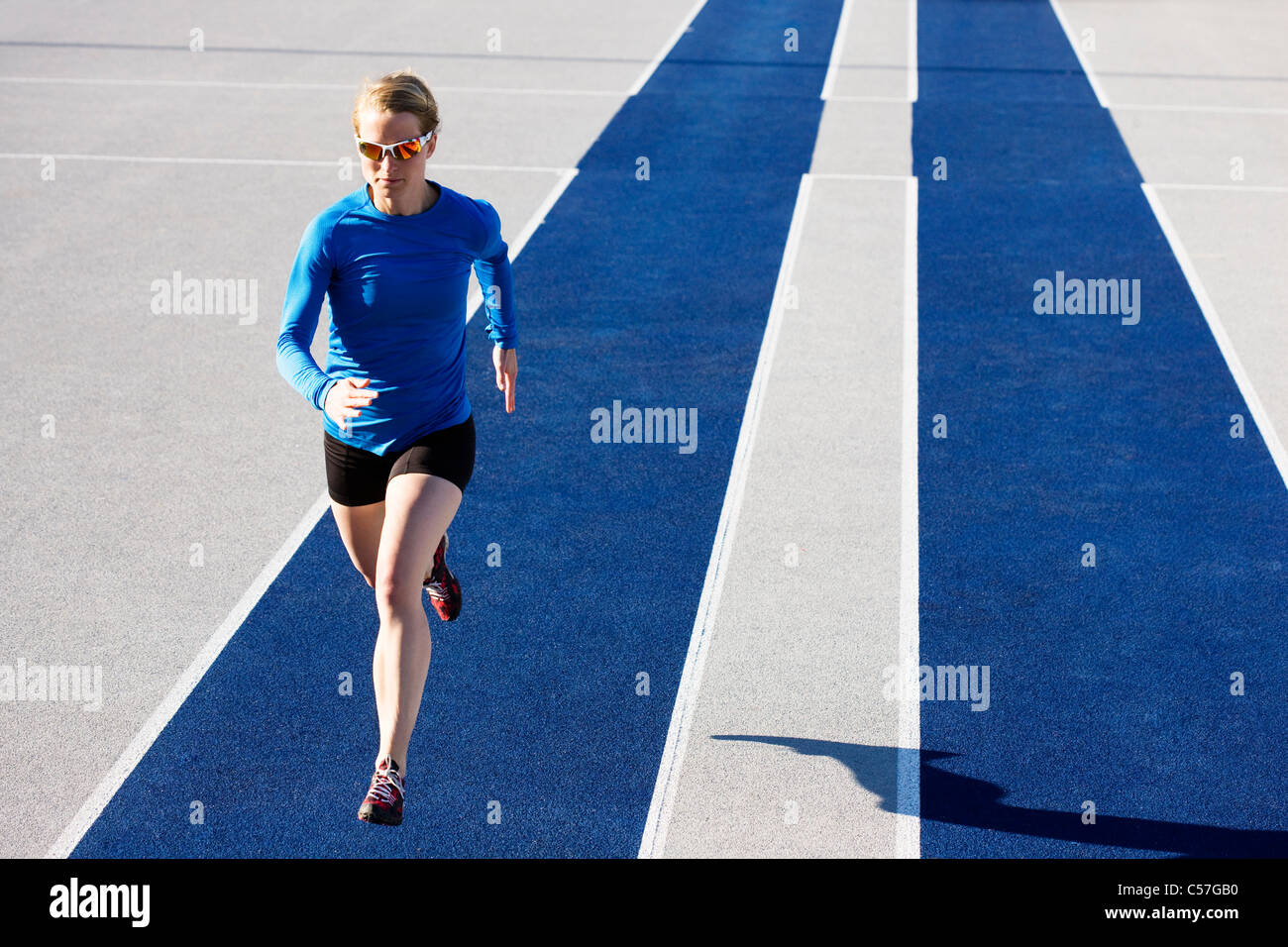 Woman running on track Stock Photo - Alamy