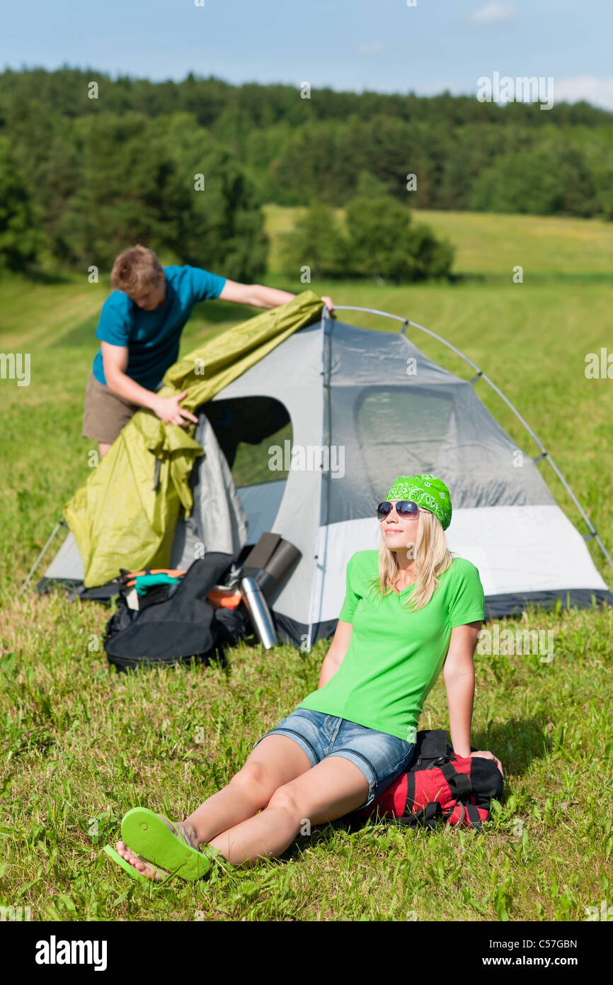 Young camping couple build-up tent in summer meadows countryside Stock ...