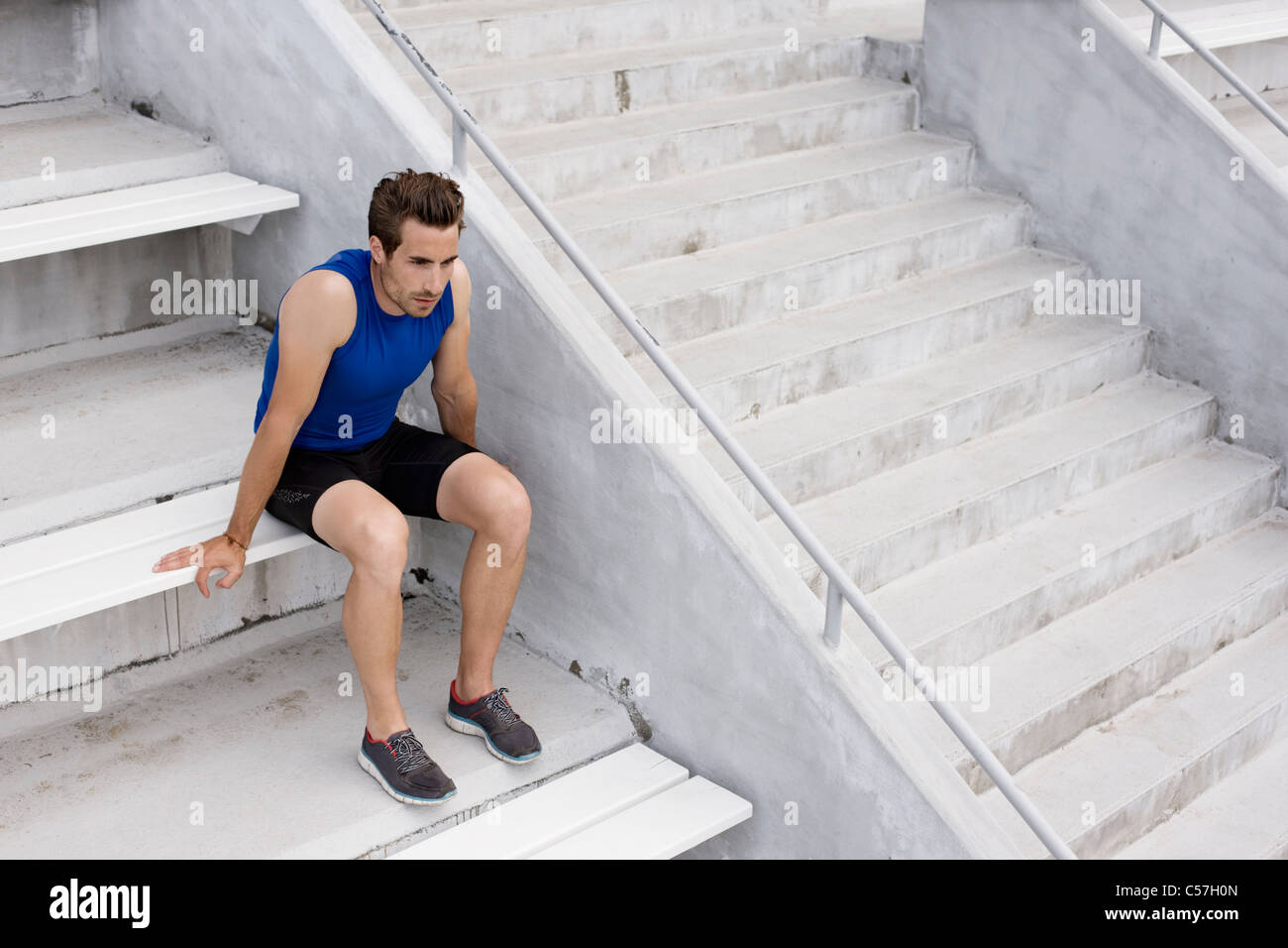 Runner resting on stadium steps Stock Photo - Alamy