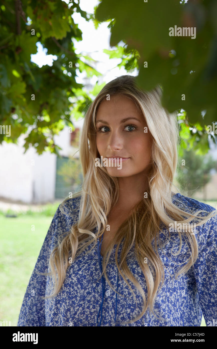 Smiling woman standing under tree Stock Photo - Alamy