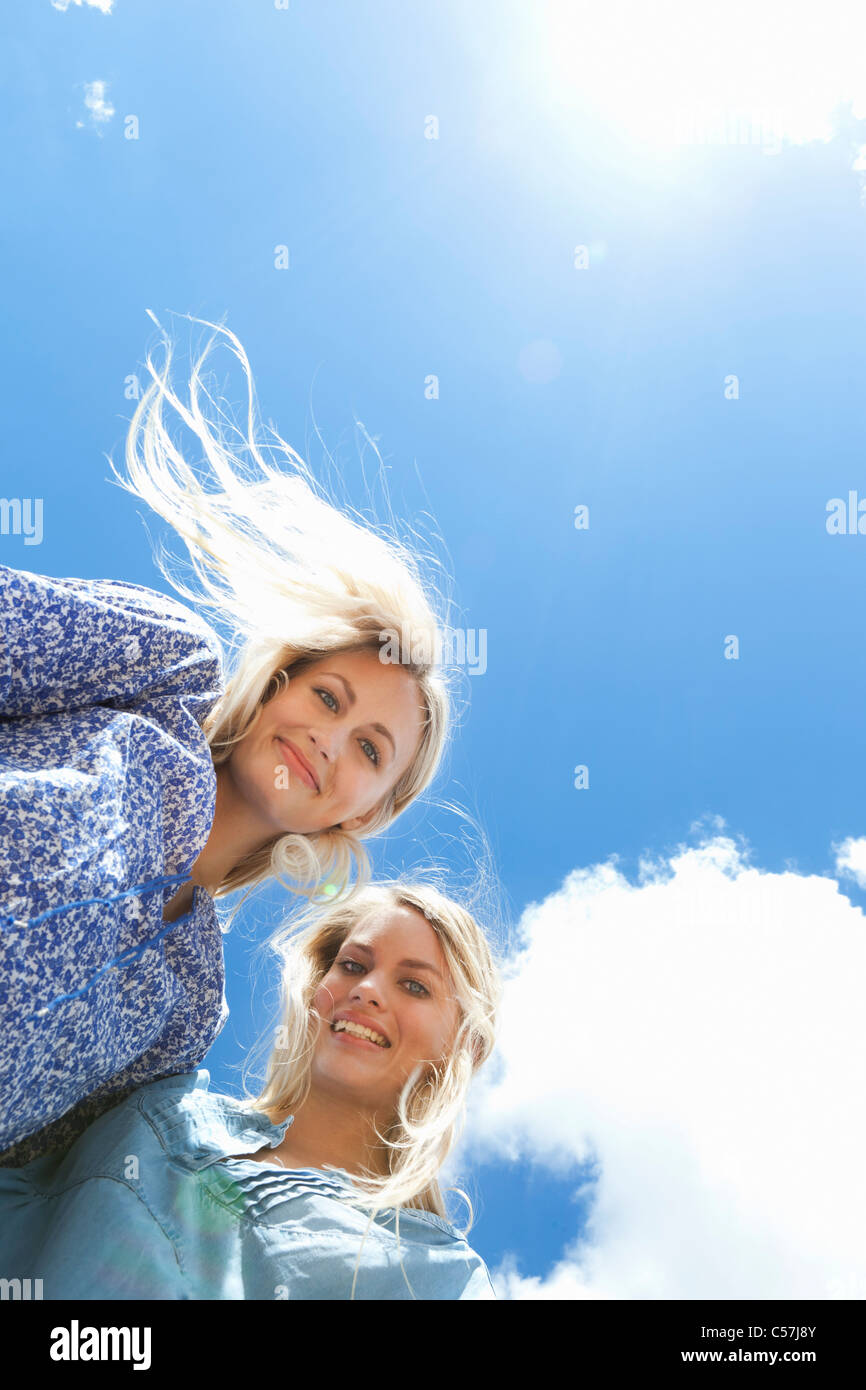 Low angle view of sisters hugging Stock Photo - Alamy