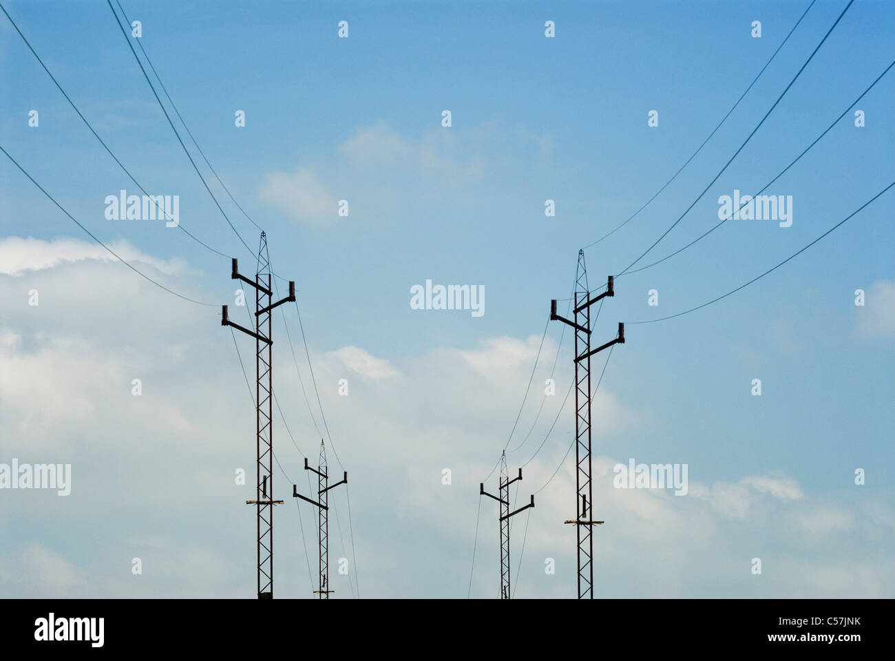 Power lines against blue sky Stock Photo - Alamy
