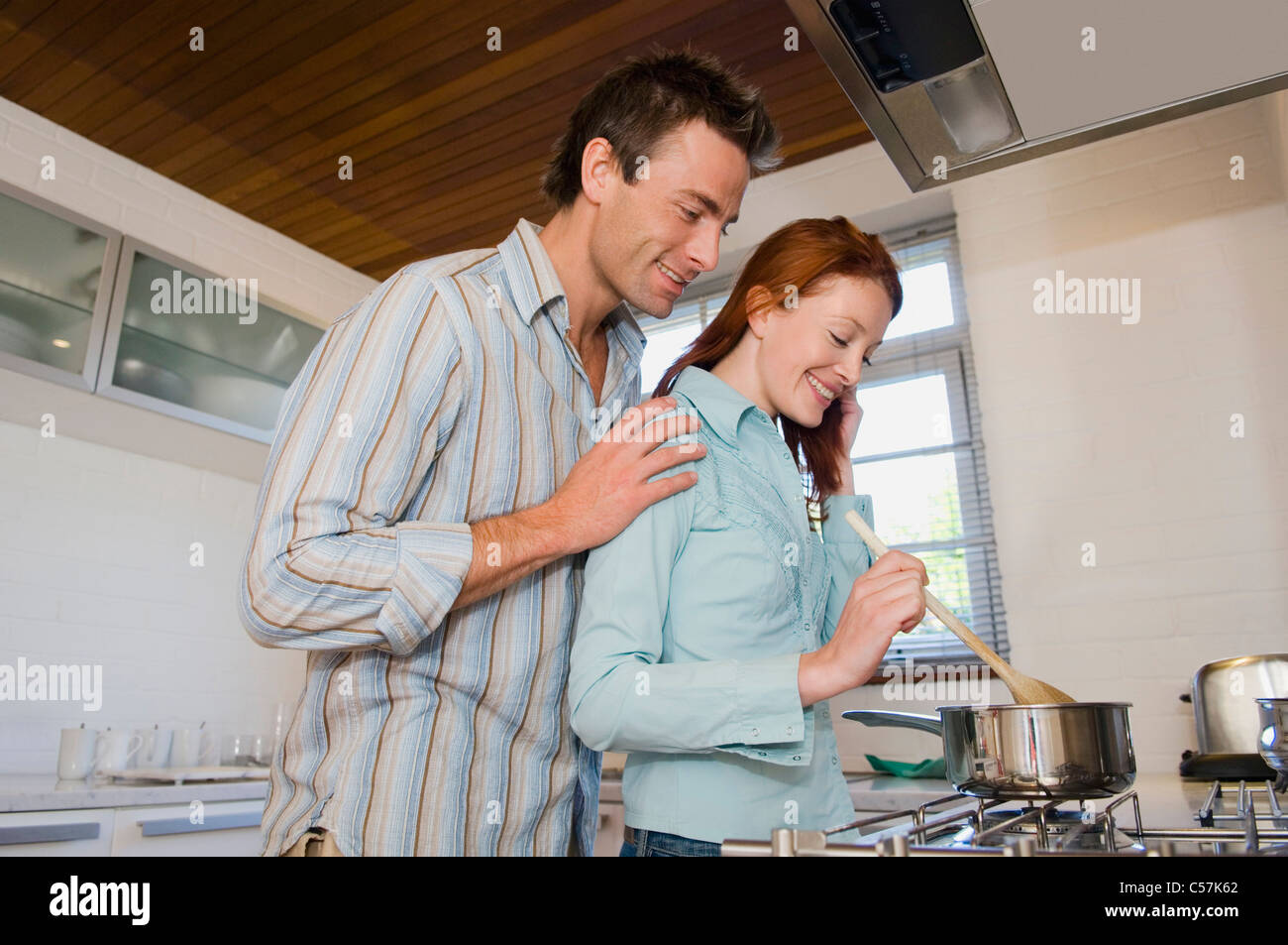 Couple cooking together in kitchen Stock Photo - Alamy