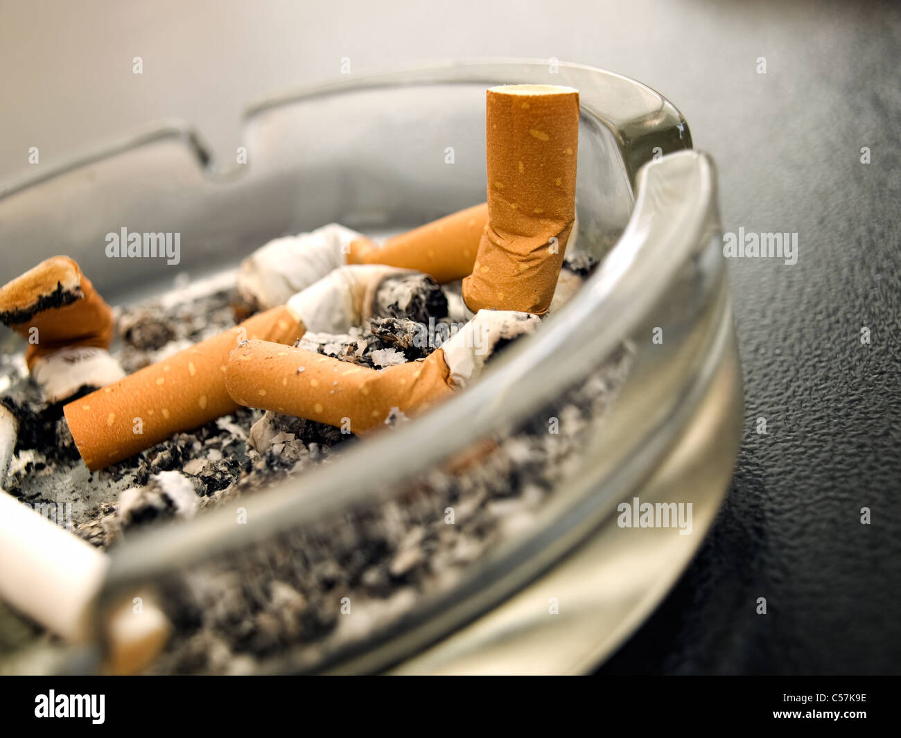 Closeup view of full ashtray on the table Stock Photo - Alamy