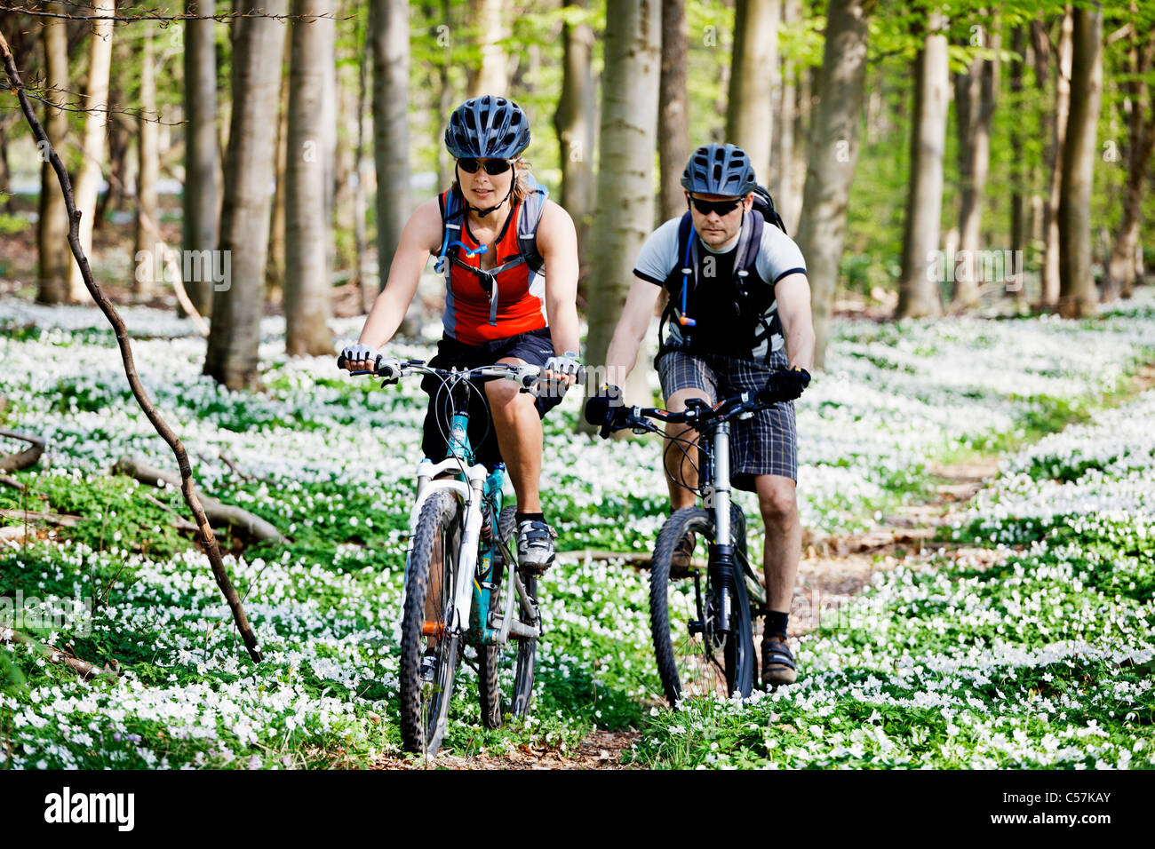 Couple mountain biking together Stock Photo - Alamy