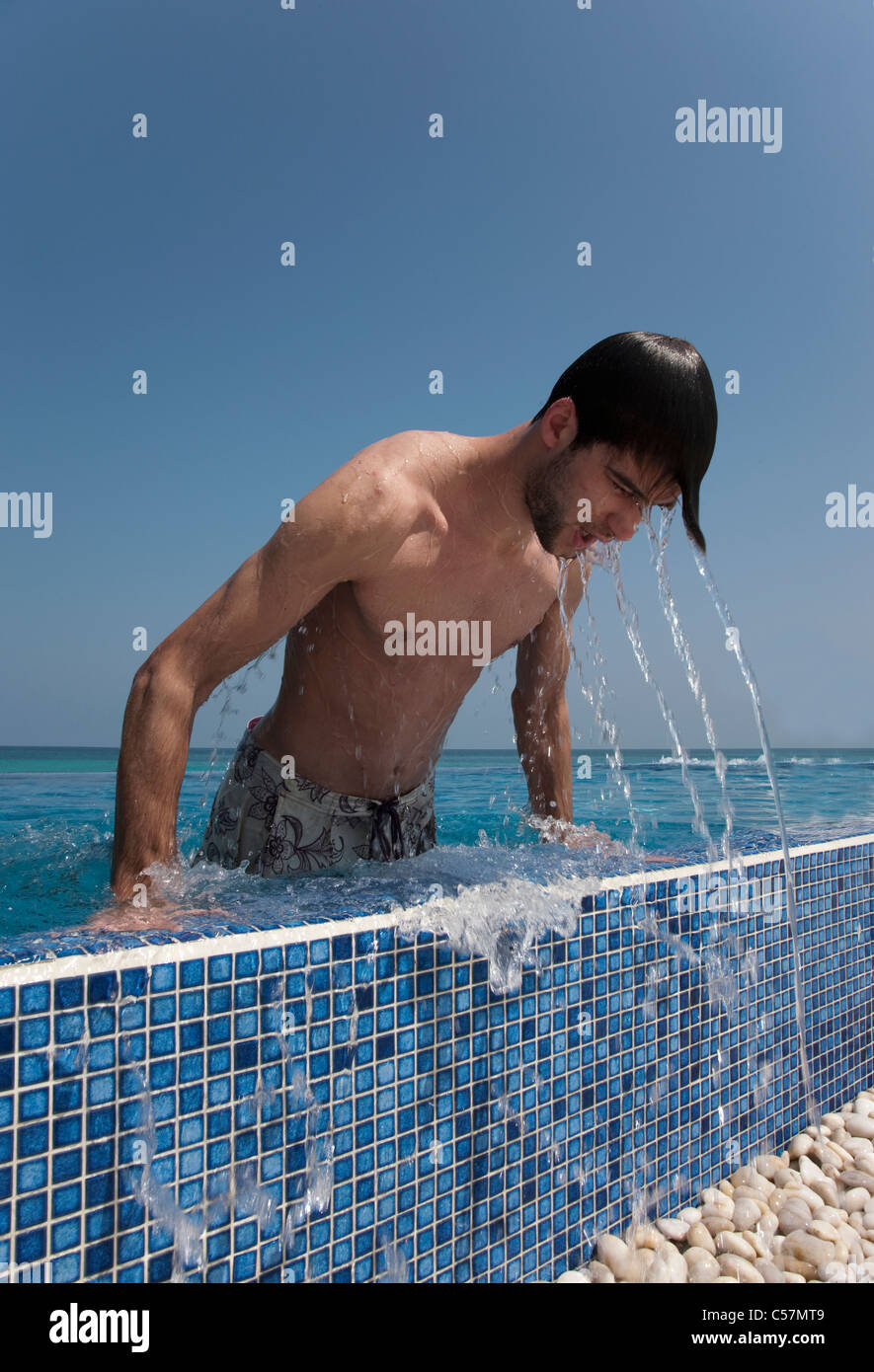 Man climbing out of infinity pool Stock Photo - Alamy