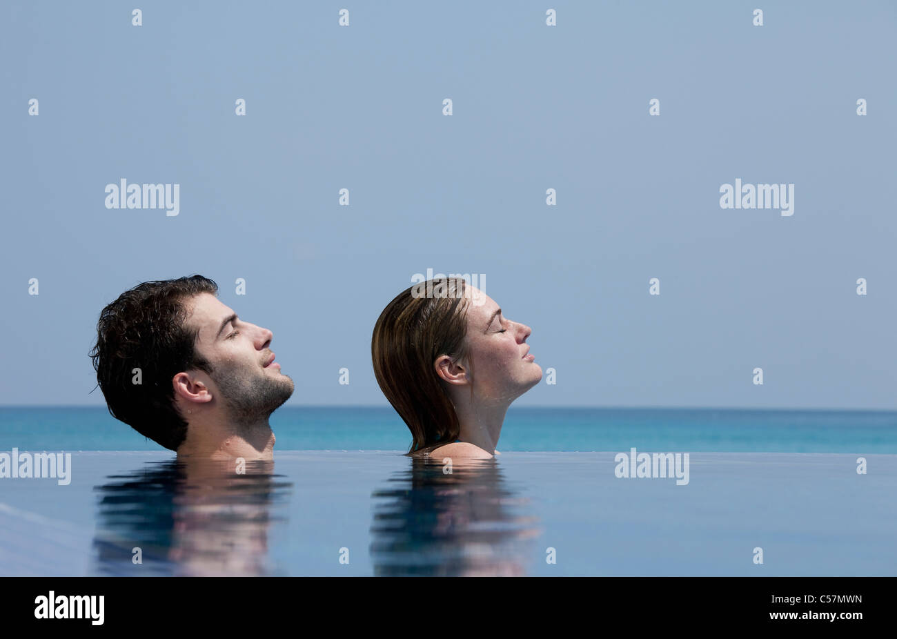 Couple relaxing in infinity pool Stock Photo - Alamy