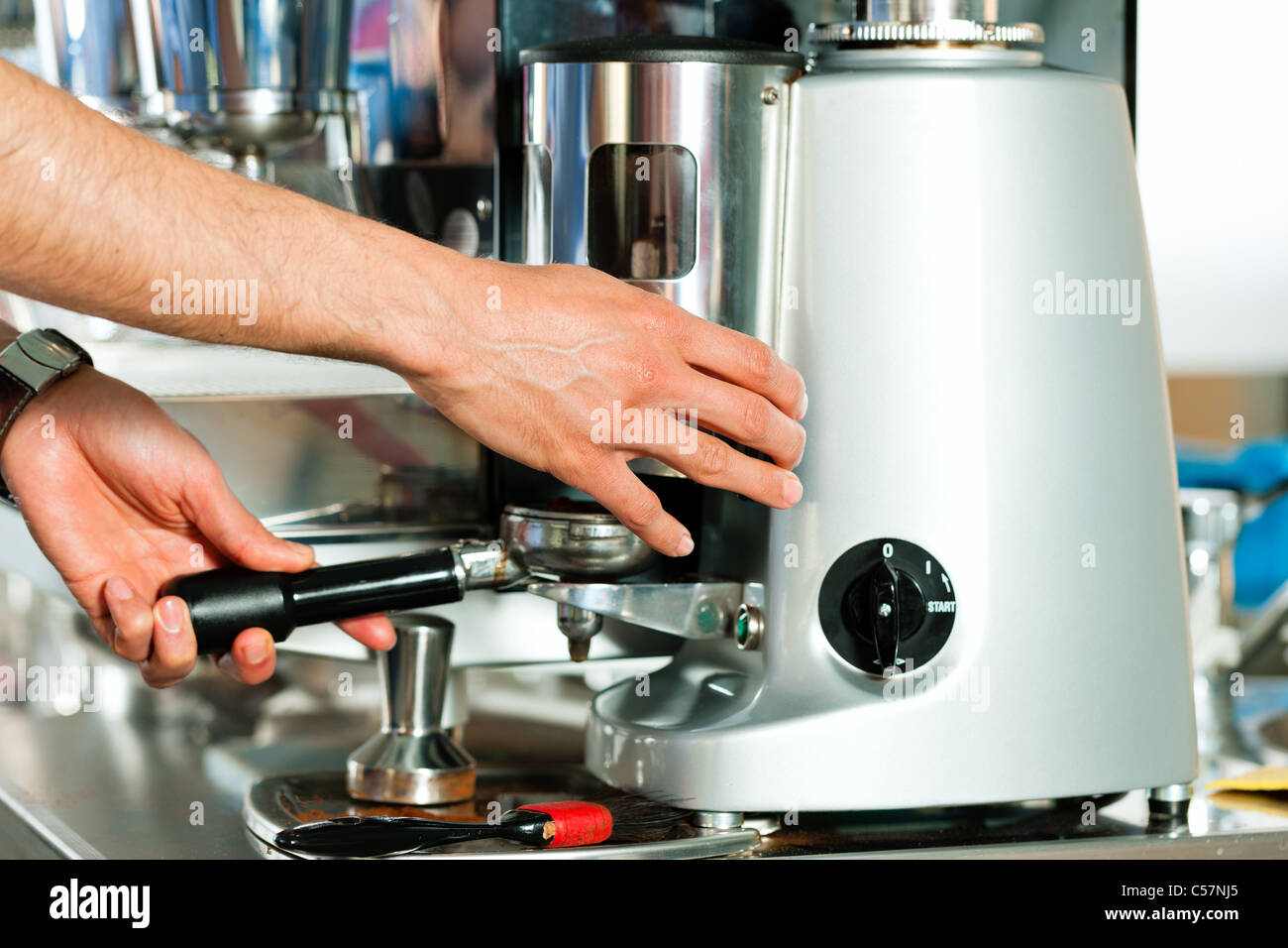 Barista prepares espresso in his coffeeshop; close-up Stock Photo - Alamy