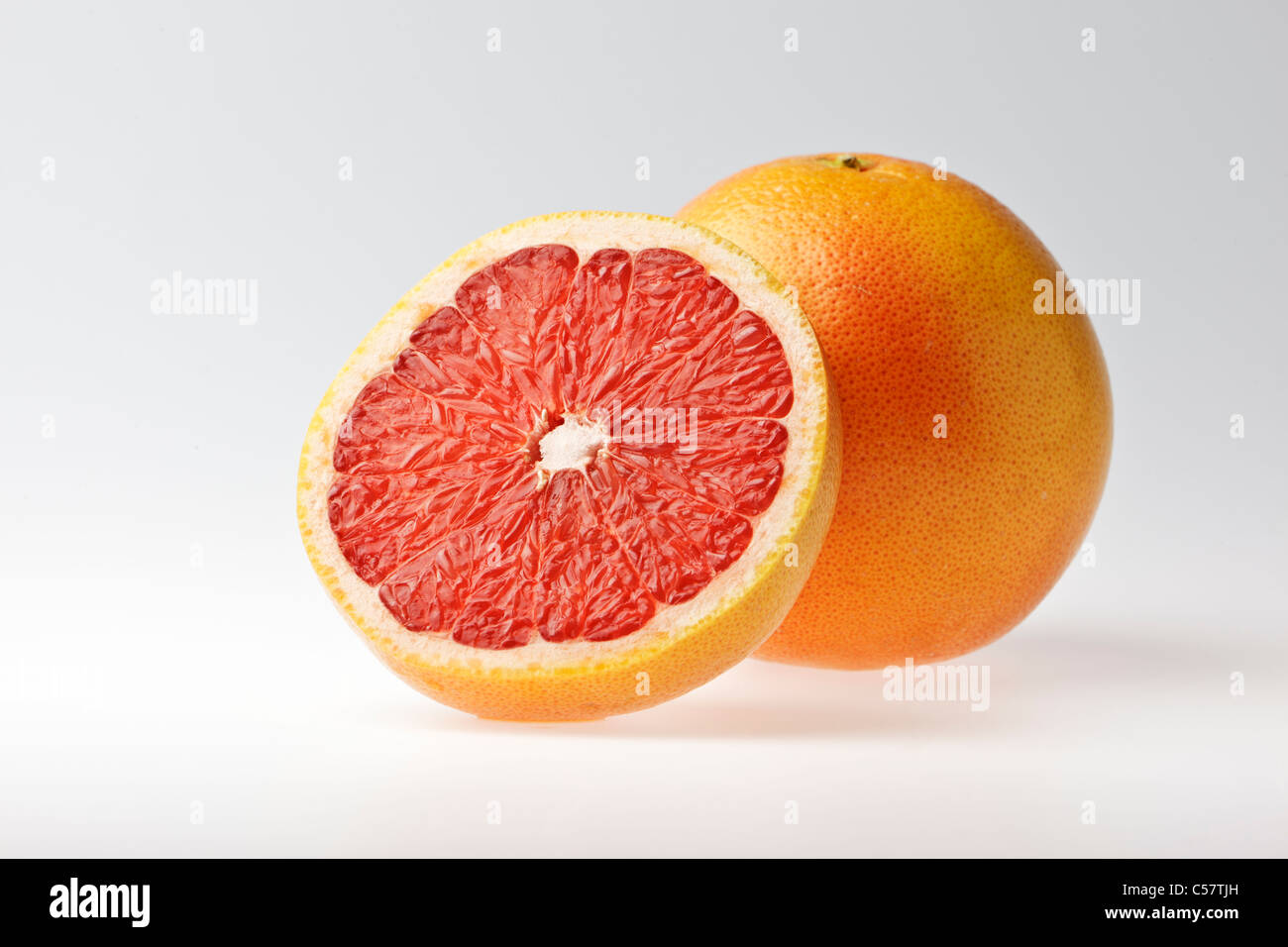 Pink grapefruit against a plain background Stock Photo - Alamy