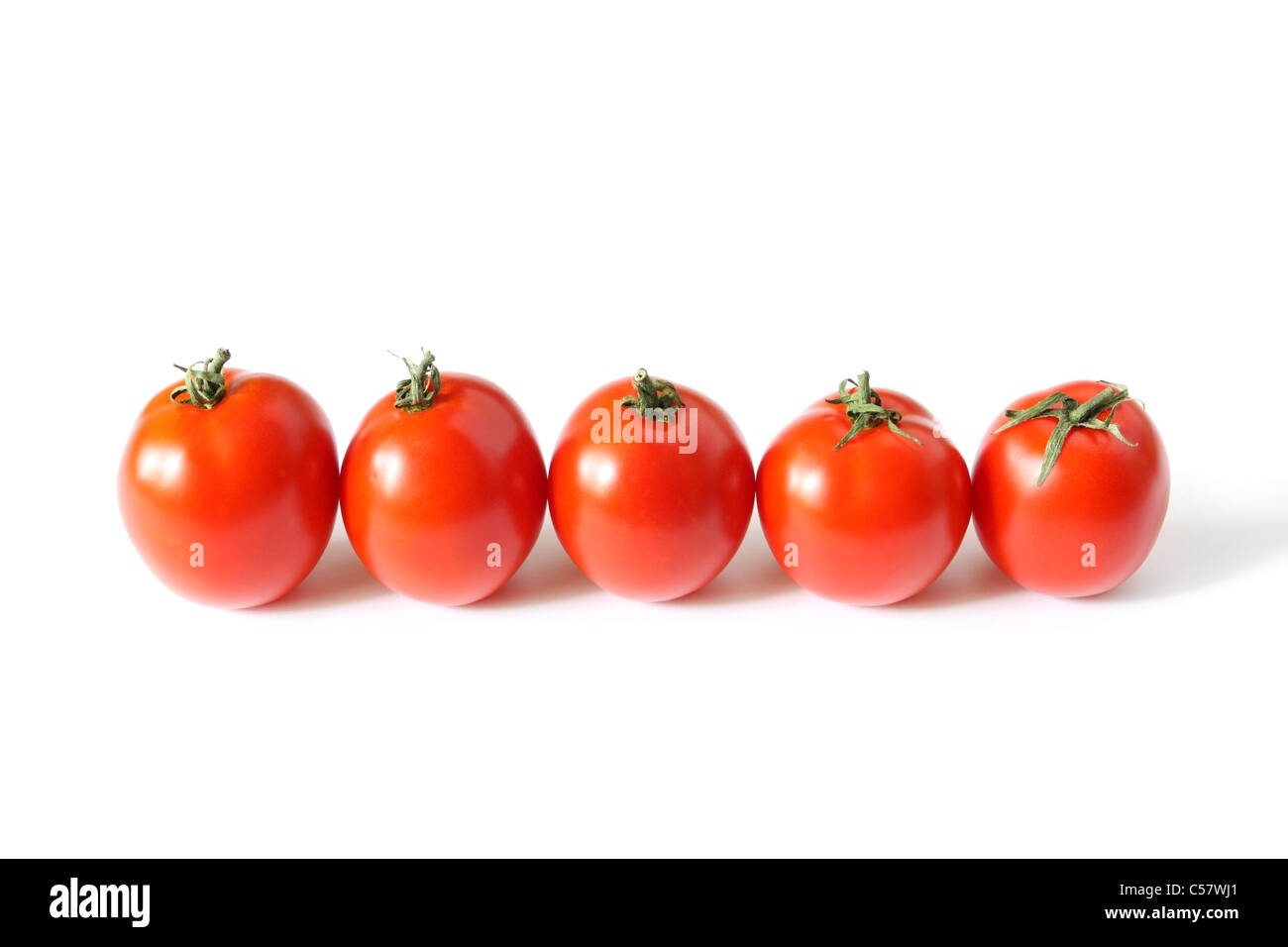 Five red tomatoes standing in a row on a white background Stock Photo ...