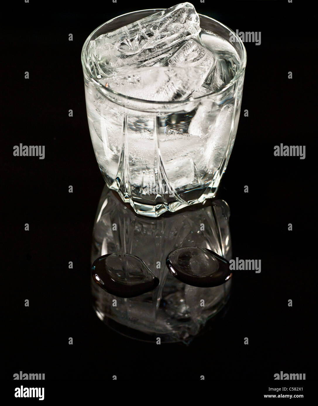 Vodka on the rocks photographed on black acrylic plastic Stock Photo ...