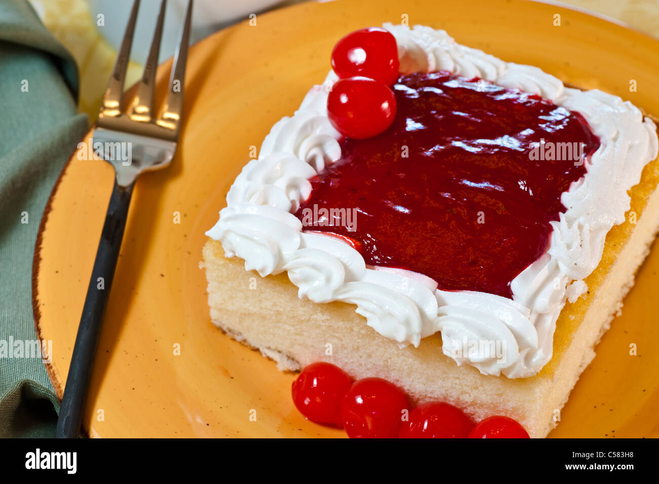 White cake with cherry and whipped cream topping Stock Photo - Alamy