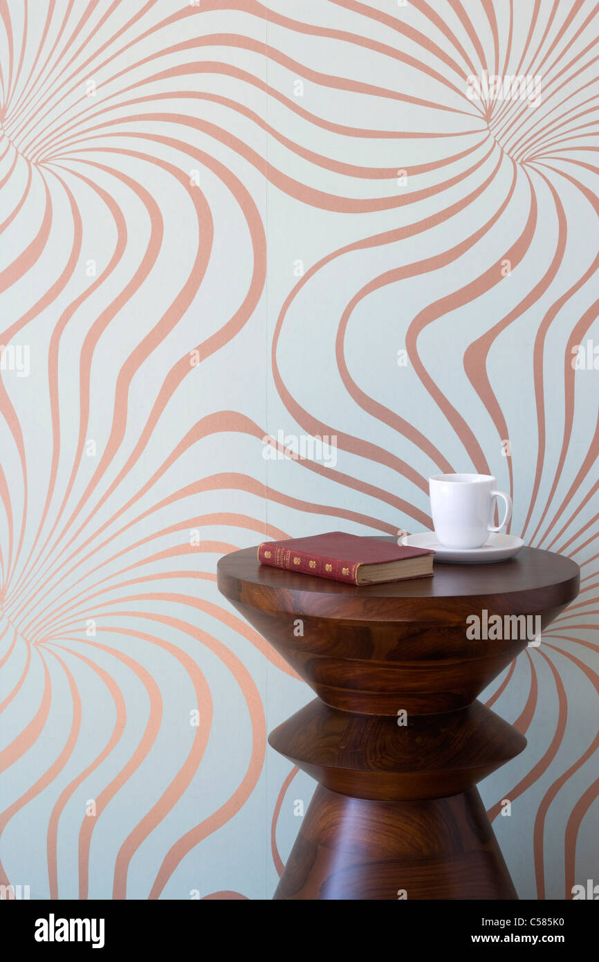 Vortex wallpaper with stool, book and cup and saucer Stock Photo - Alamy