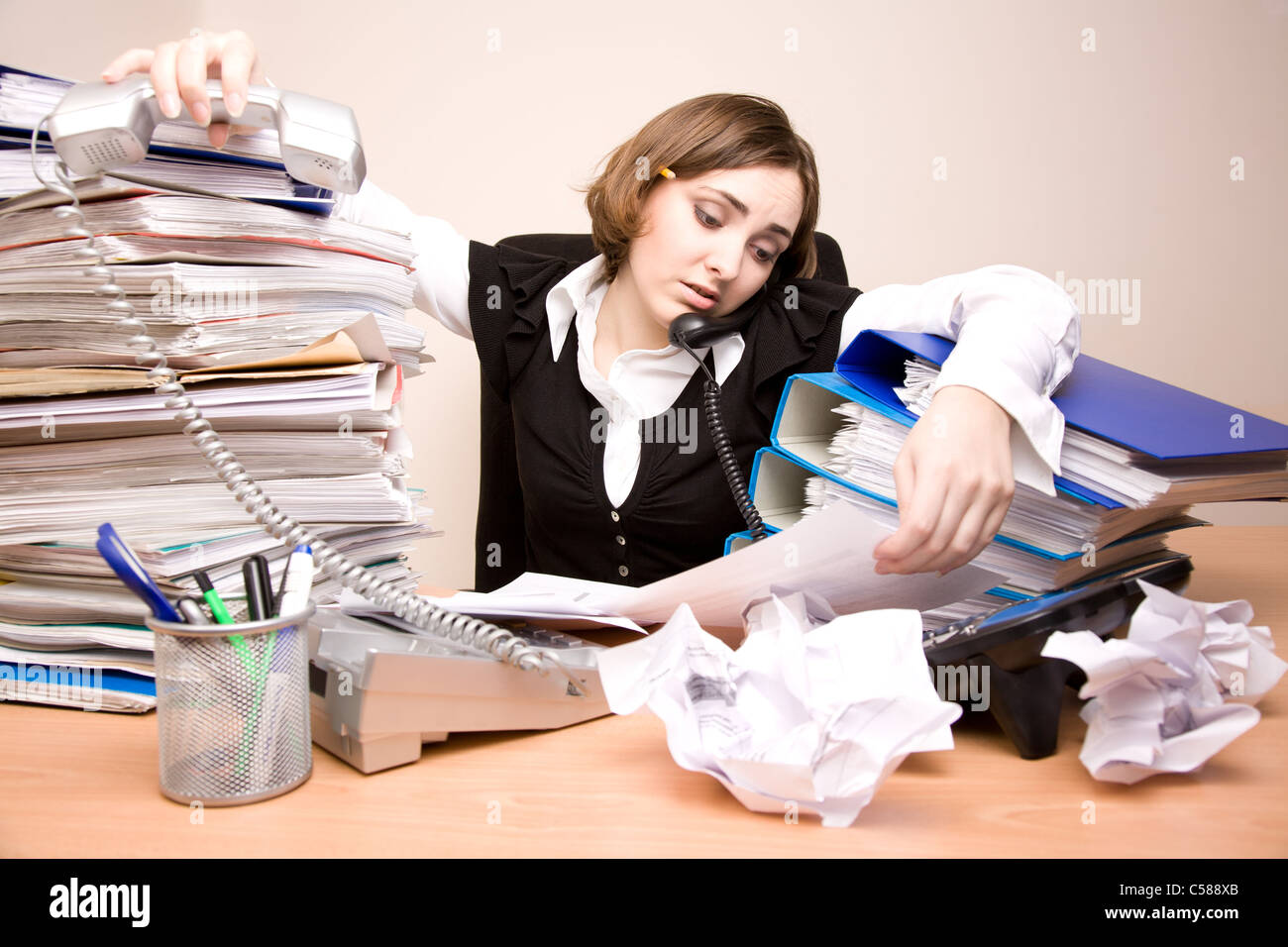 Young tired businesswoman with tons of documents calling phone Stock ...