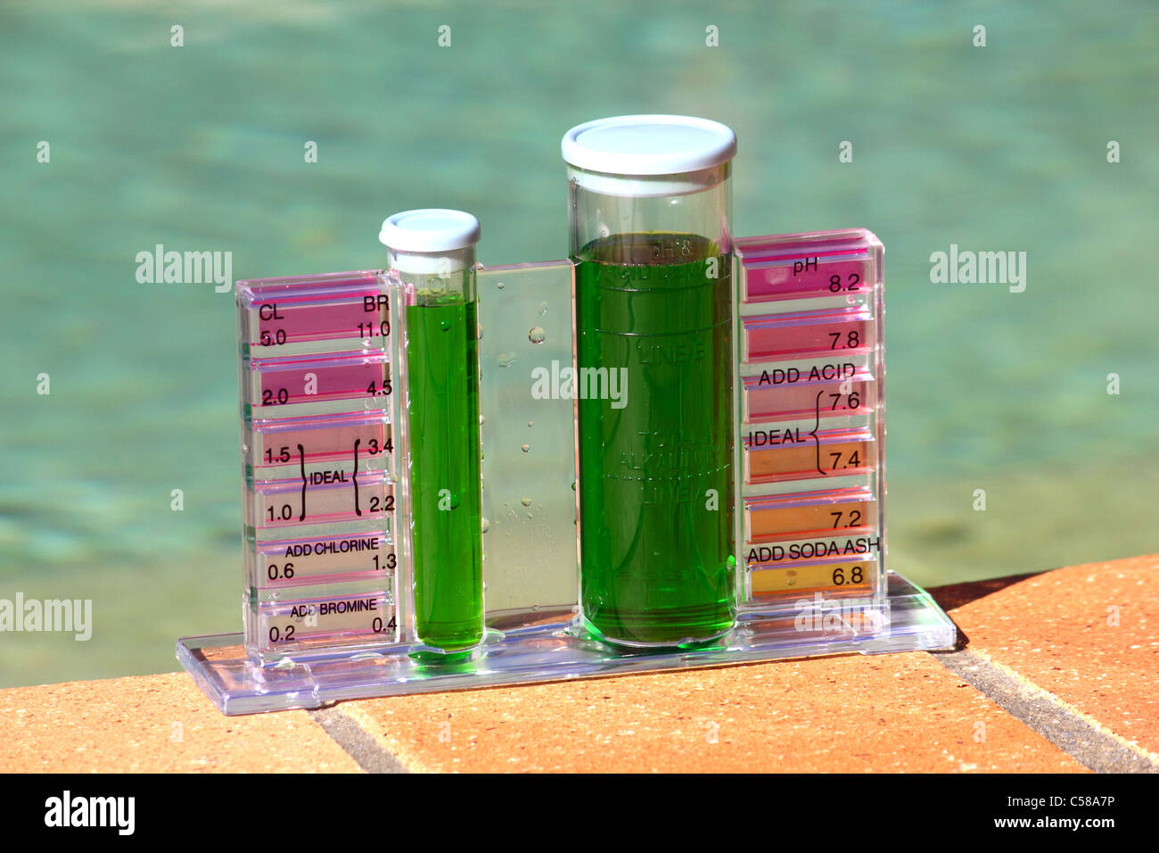 SAMPLE OF SLIMY GREEN WATER IN A POOL TEST KIT BLUE SKY AND POOLSIDE ...