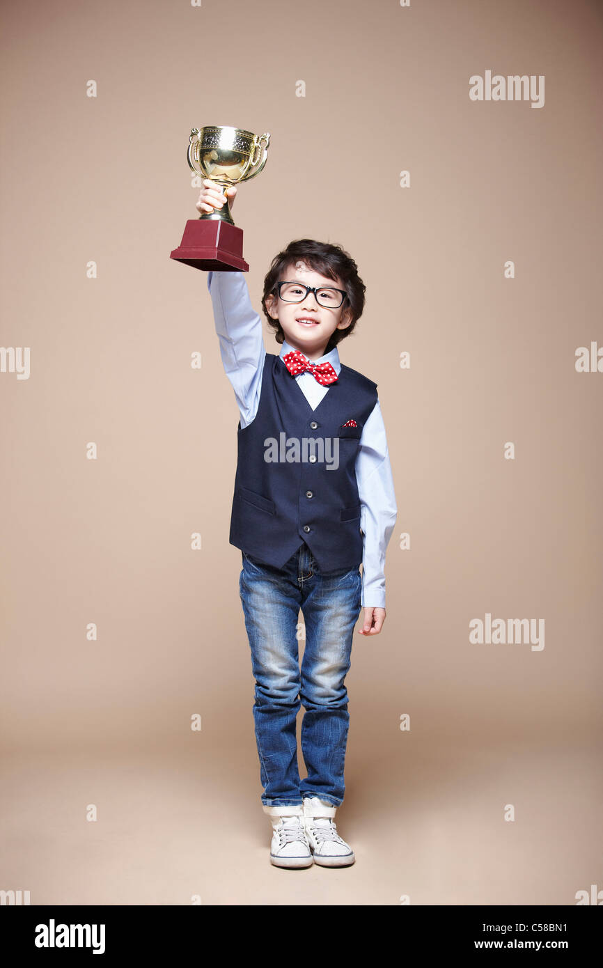 boy pick up the trophy Stock Photo - Alamy