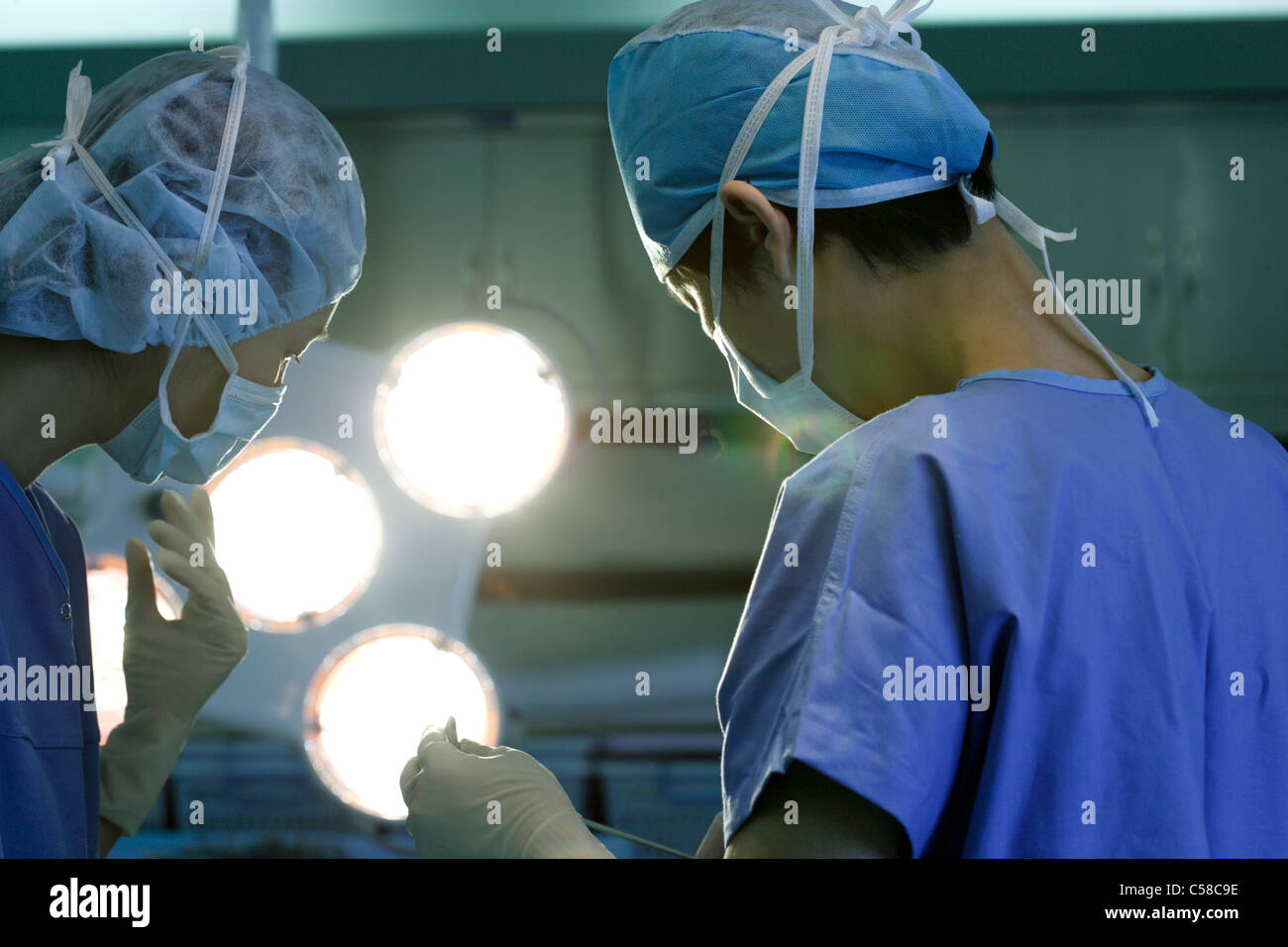 Rear view of Two surgeons operating surgery in Hospital Stock Photo - Alamy