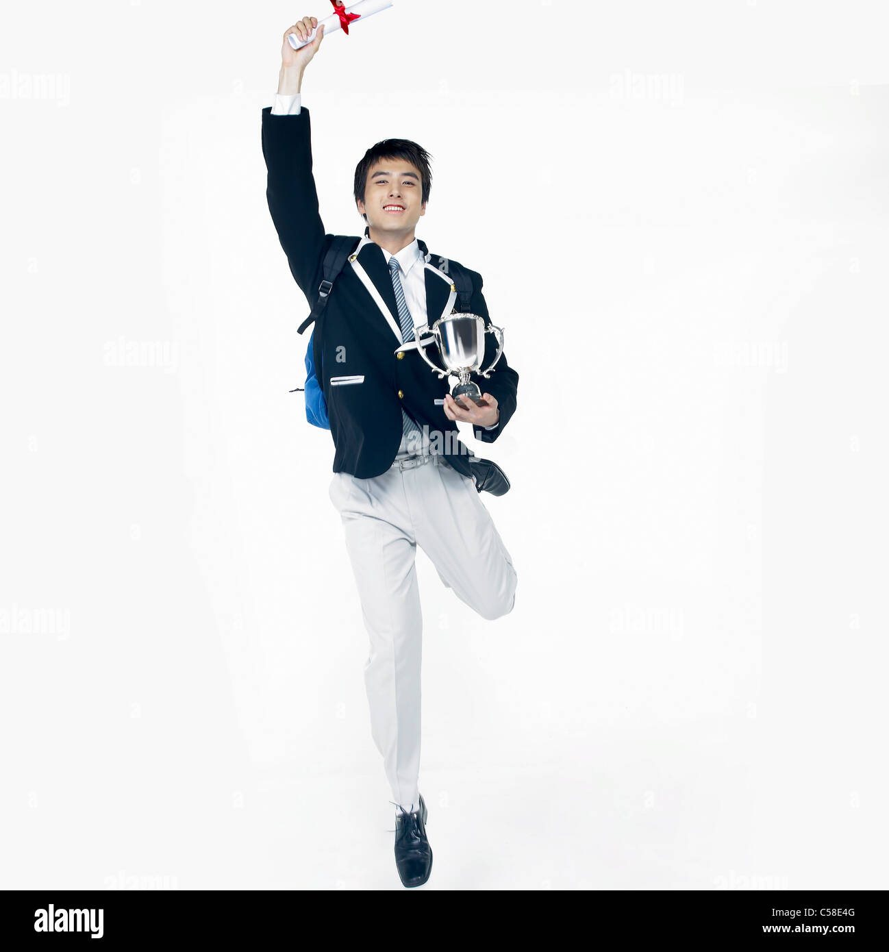 Portrait of boy standing jumping with trophy Stock Photo - Alamy