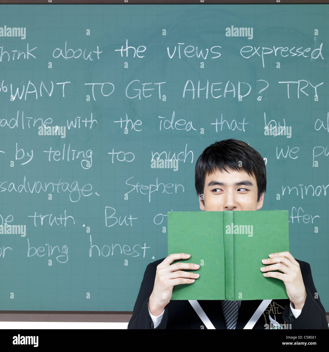 Teenage boy standing by blackboard Stock Photo - Alamy