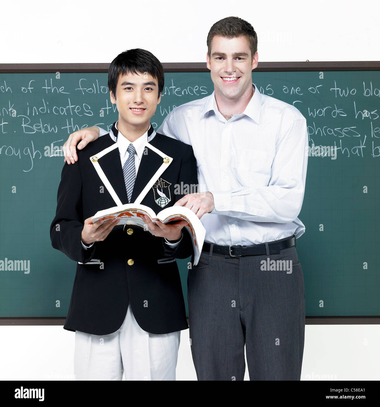 Portrait of boy and teacher standing by blackboard Stock Photo - Alamy