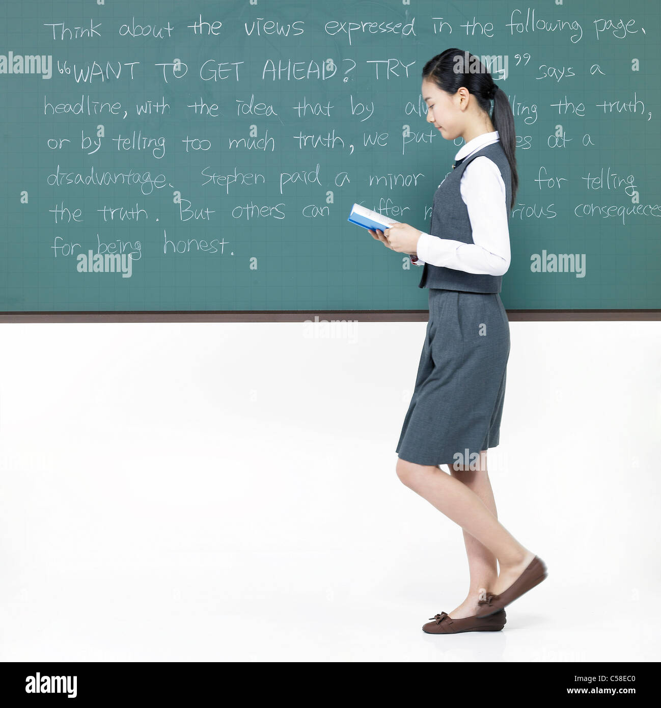 Side view of teenage girl walking by blackboard Stock Photo - Alamy