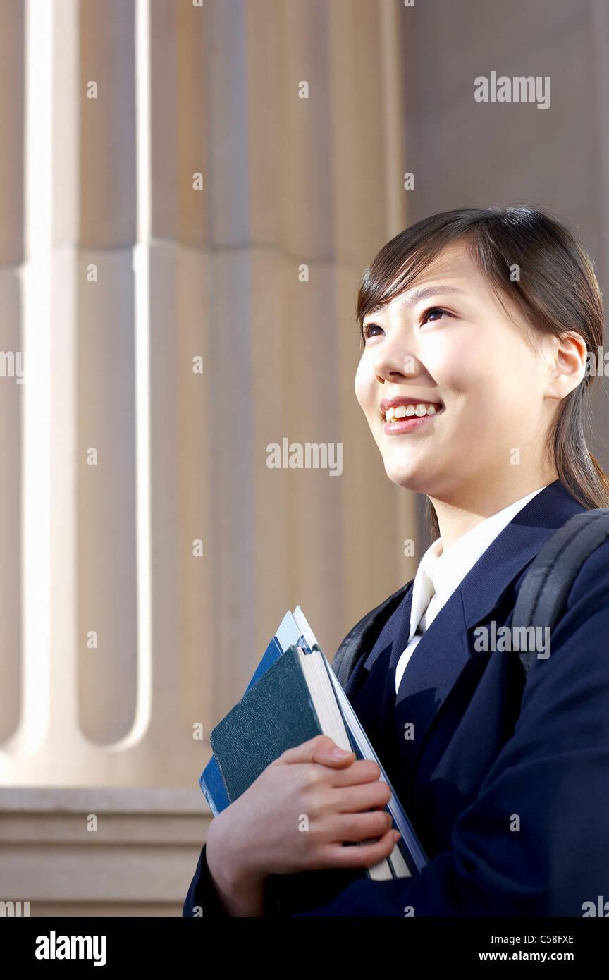 Side view of teenage girl standing in college Stock Photo - Alamy