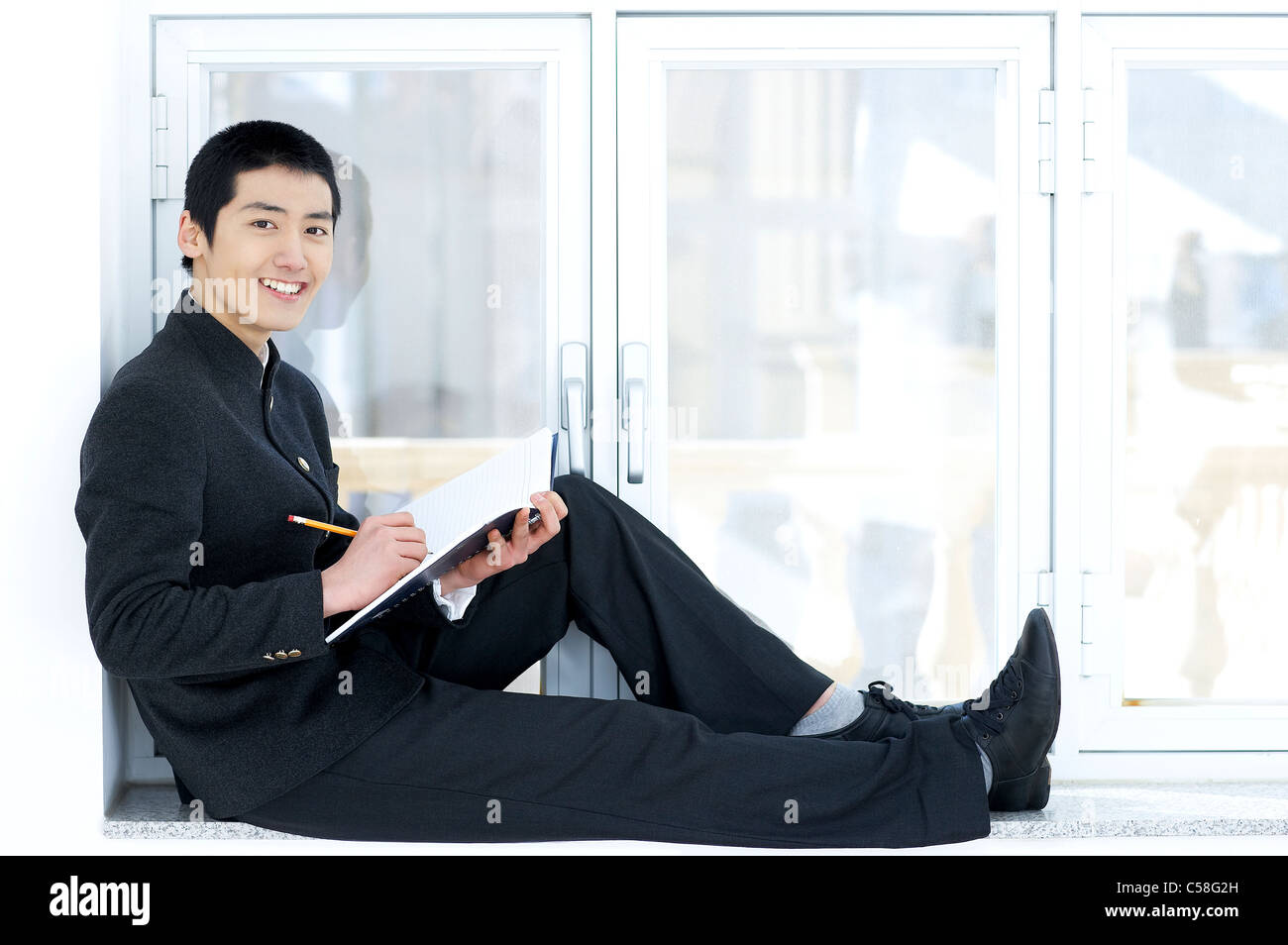 Portrait of teenage boy writing in book Stock Photo - Alamy