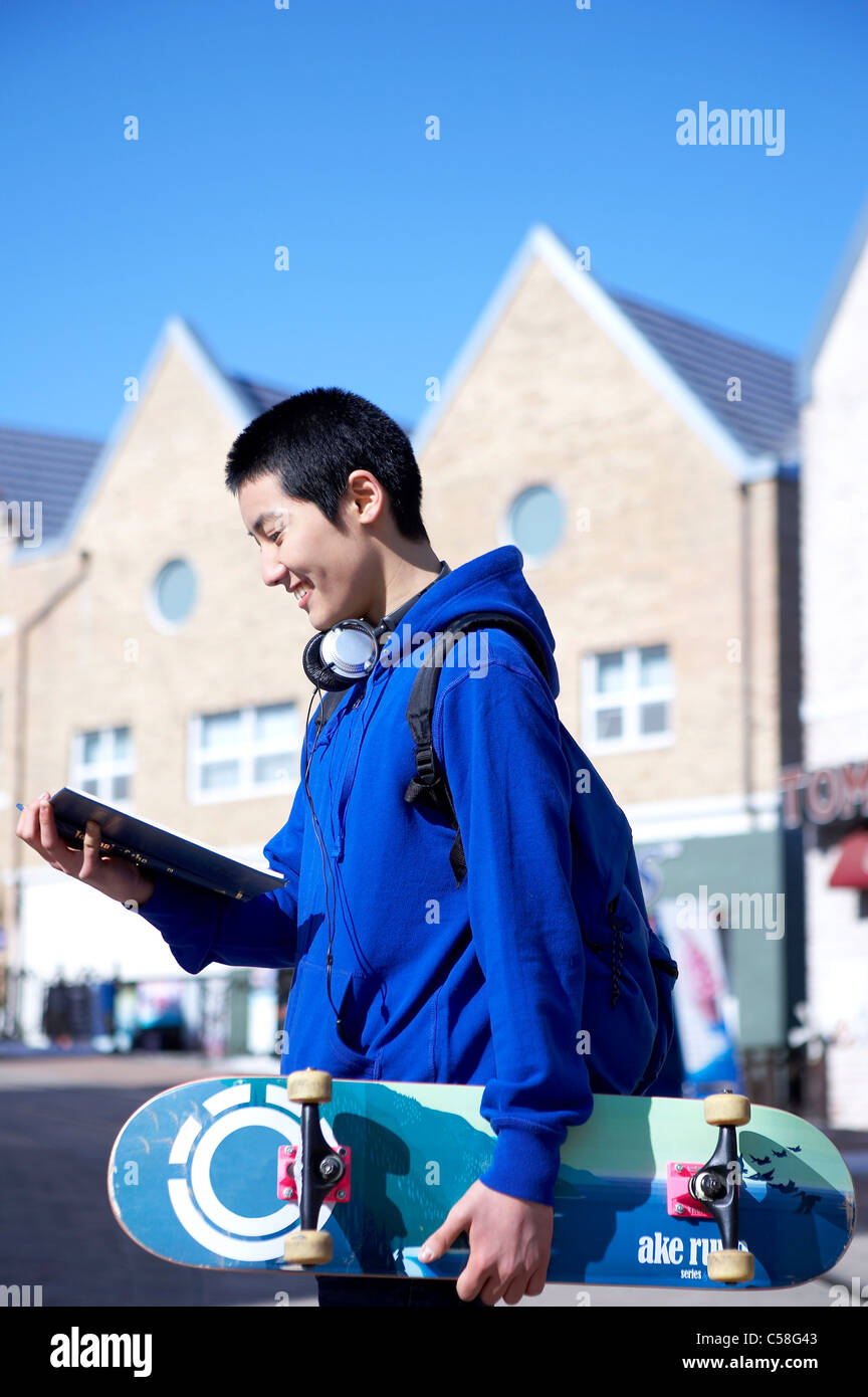 Side view of teenage boy walking on street Stock Photo - Alamy