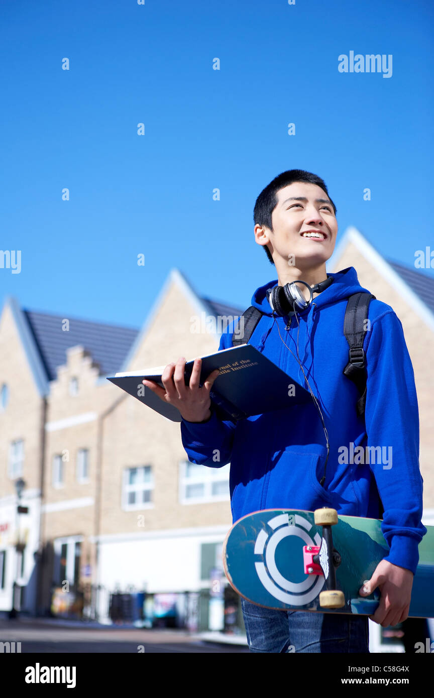 Side view of teenage boy standing on street Stock Photo - Alamy