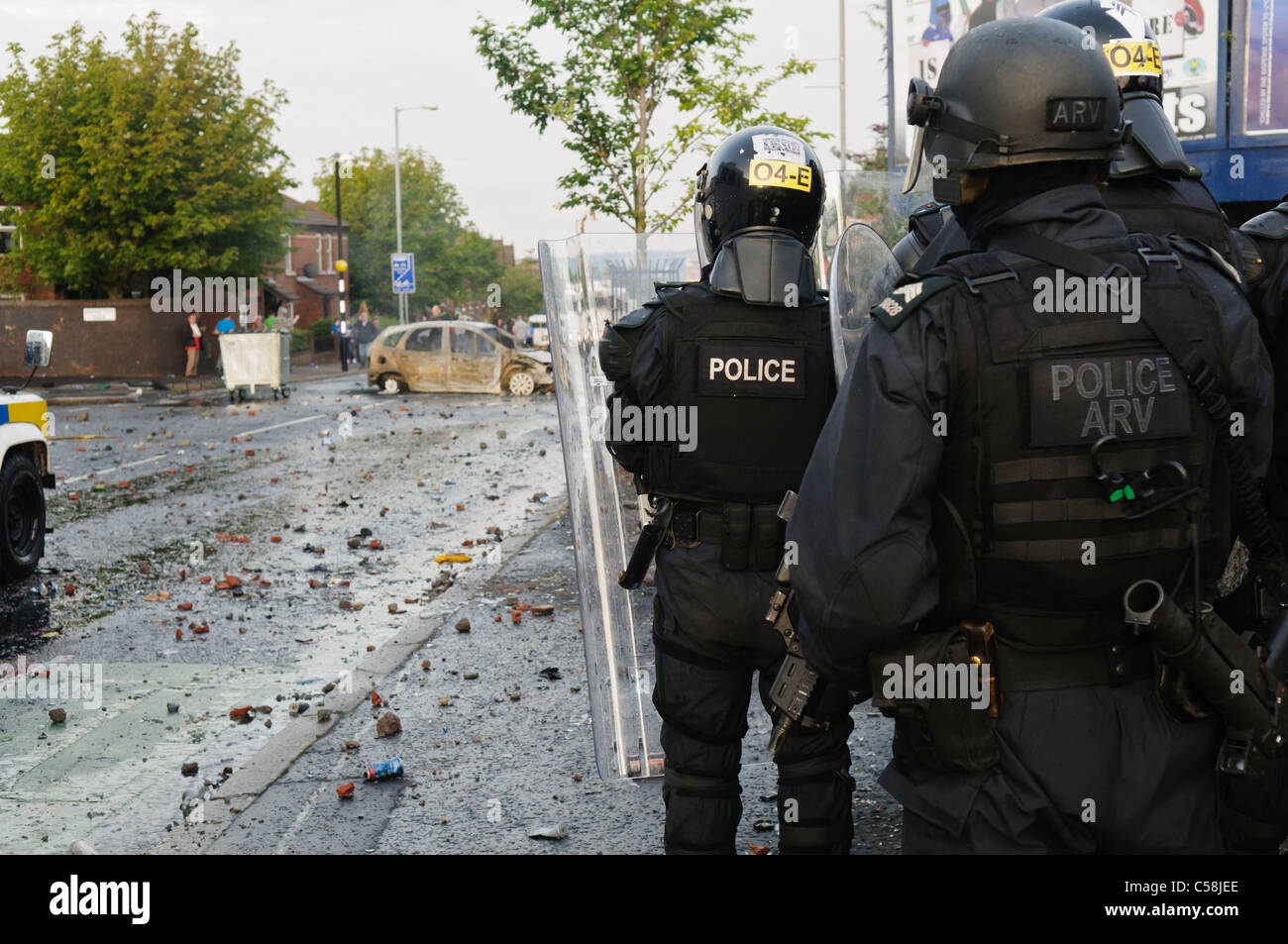 Police officers in riot gear at a riot gear watch group of rioters ...