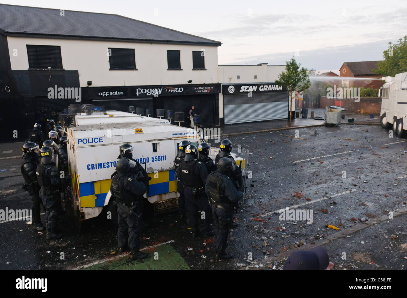 Police officers in riot gear advance behind water cannon Stock Photo ...