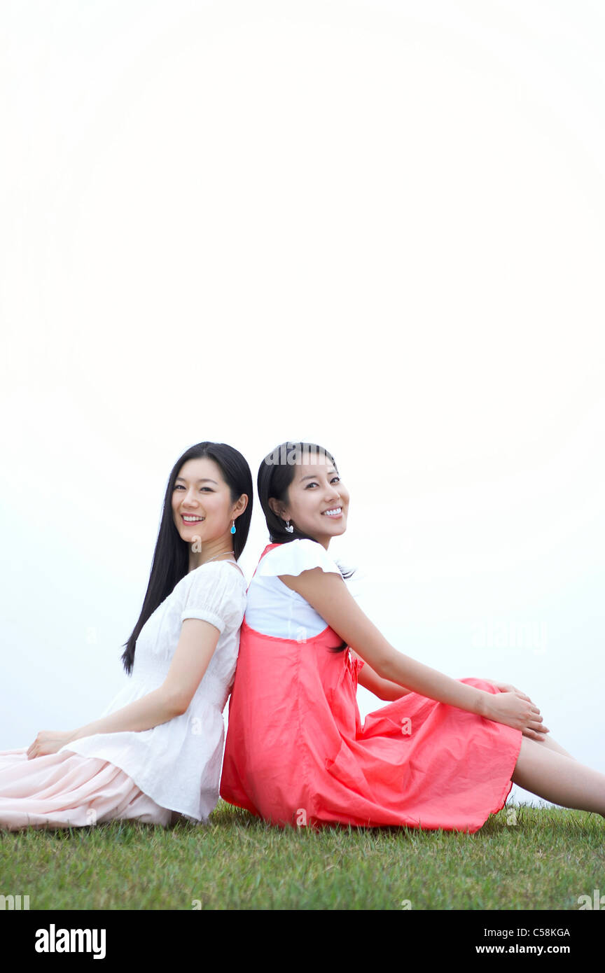 Portrait of young women sitting on grass Stock Photo - Alamy
